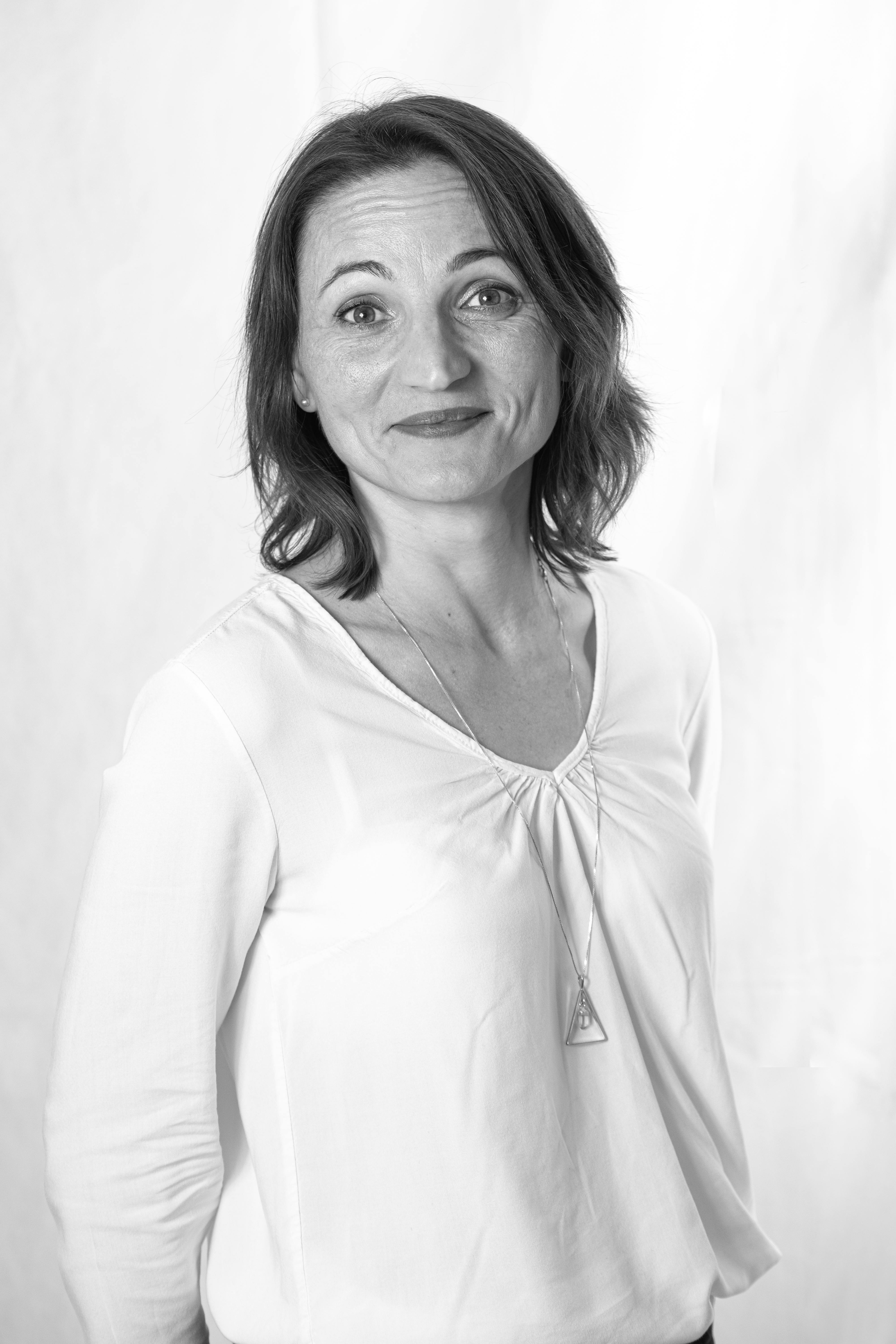 A Grayscale Photo Of A Woman In White Long Sleeves Sitting While