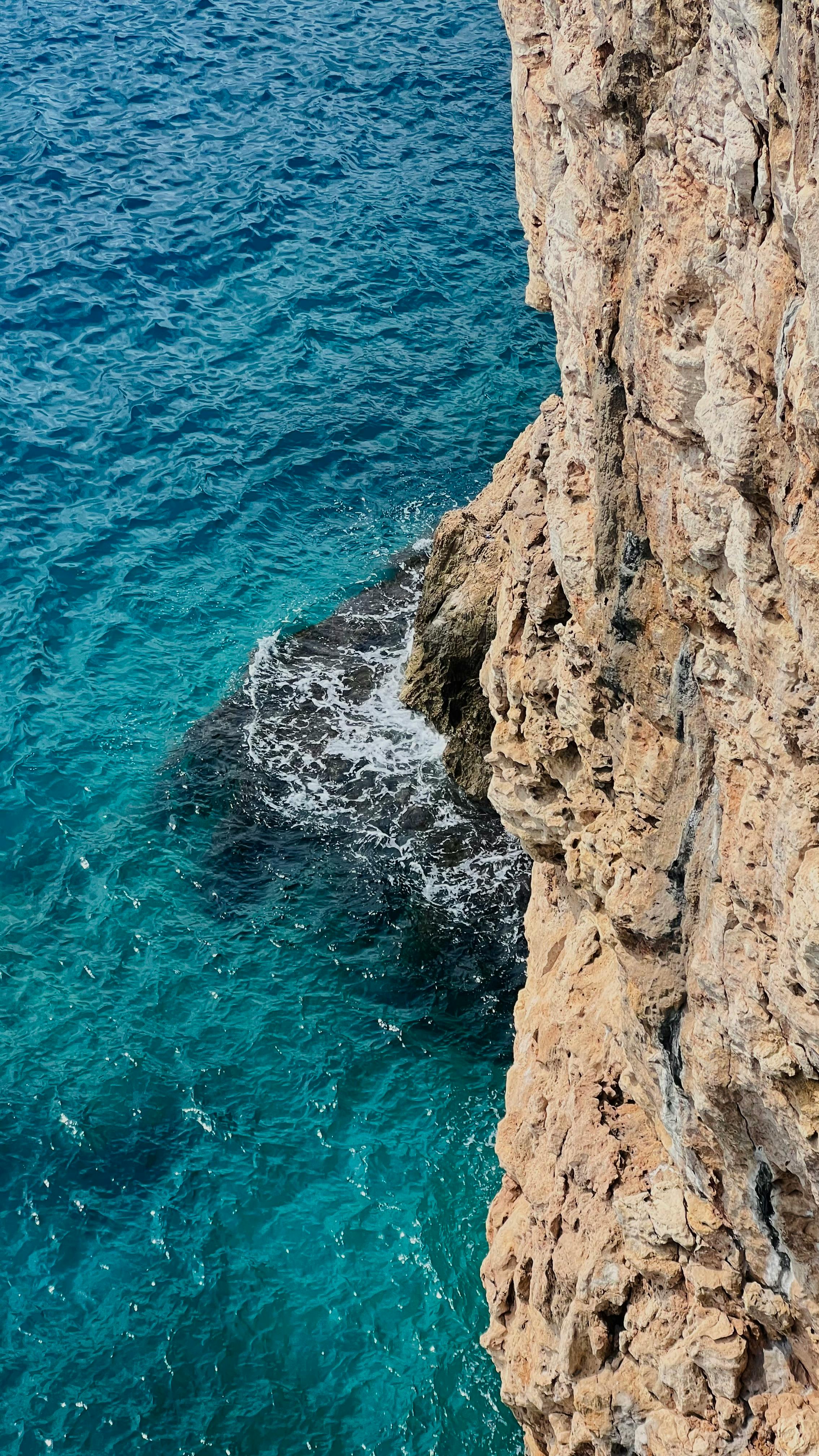 Rock Cliff near Blue Sea · Free Stock Photo