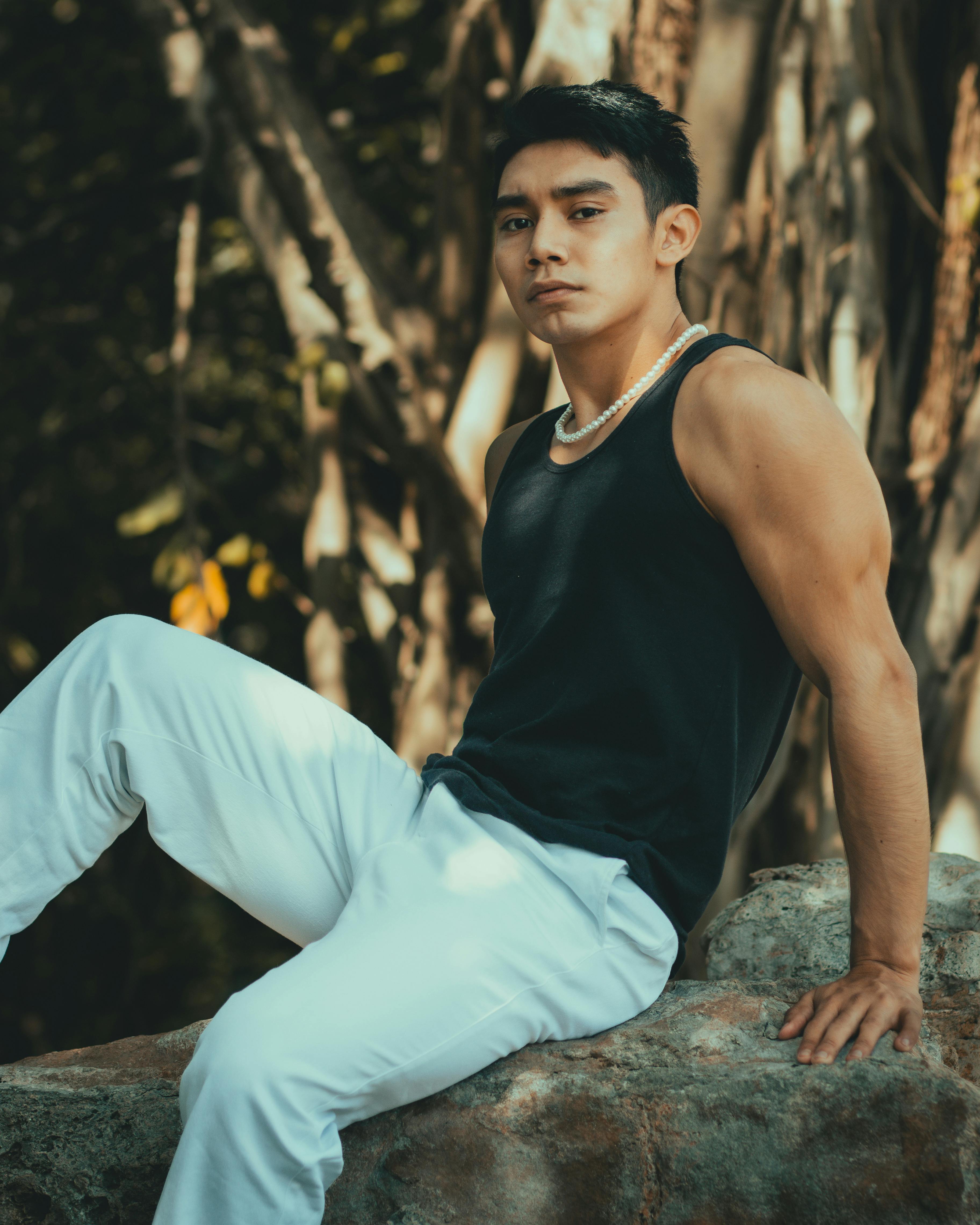 Man in Tank Top Sitting and Posing · Free Stock Photo