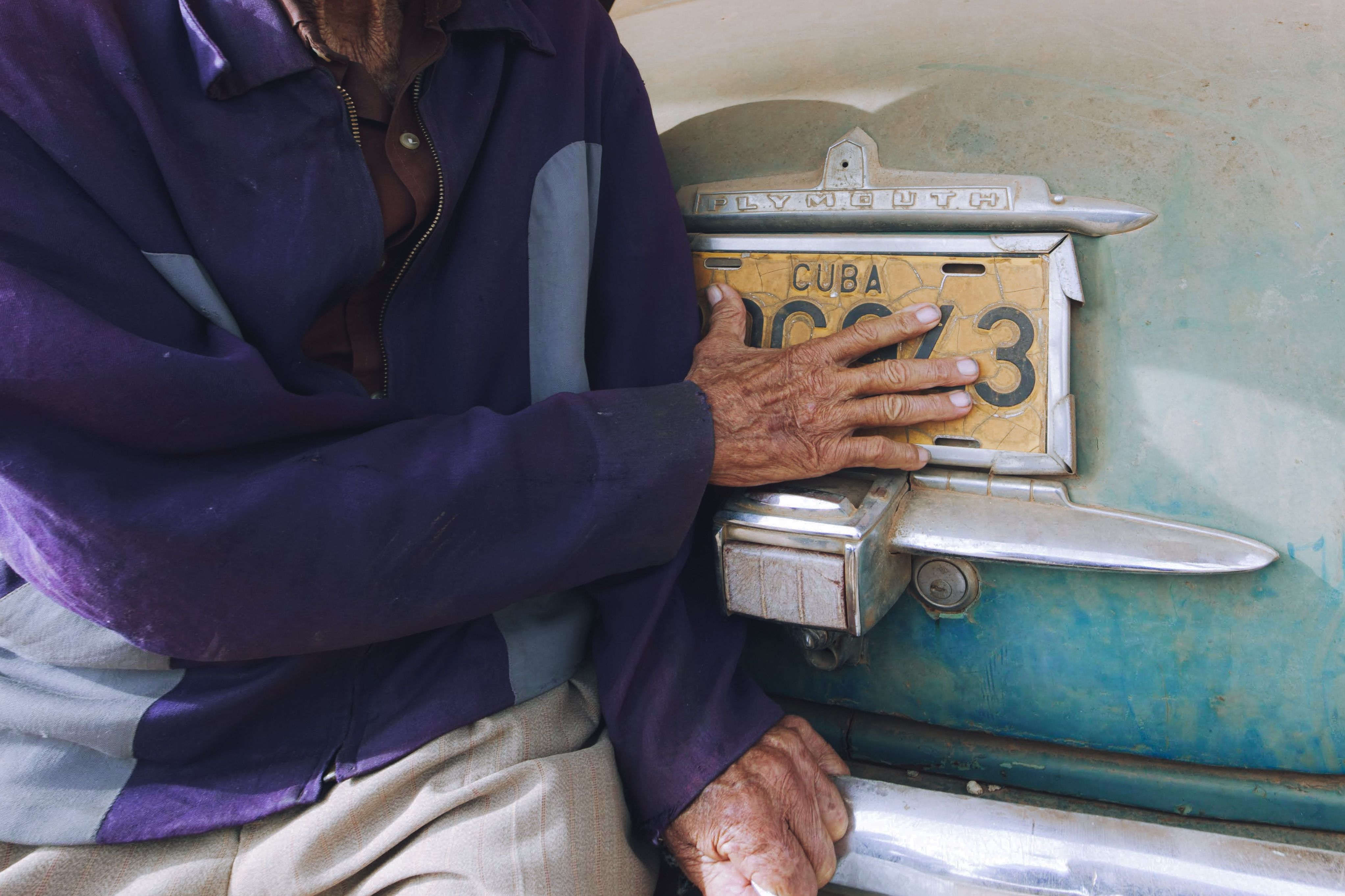 Mans Hand Touching a Licence Plate of a Car · Free Stock Photo