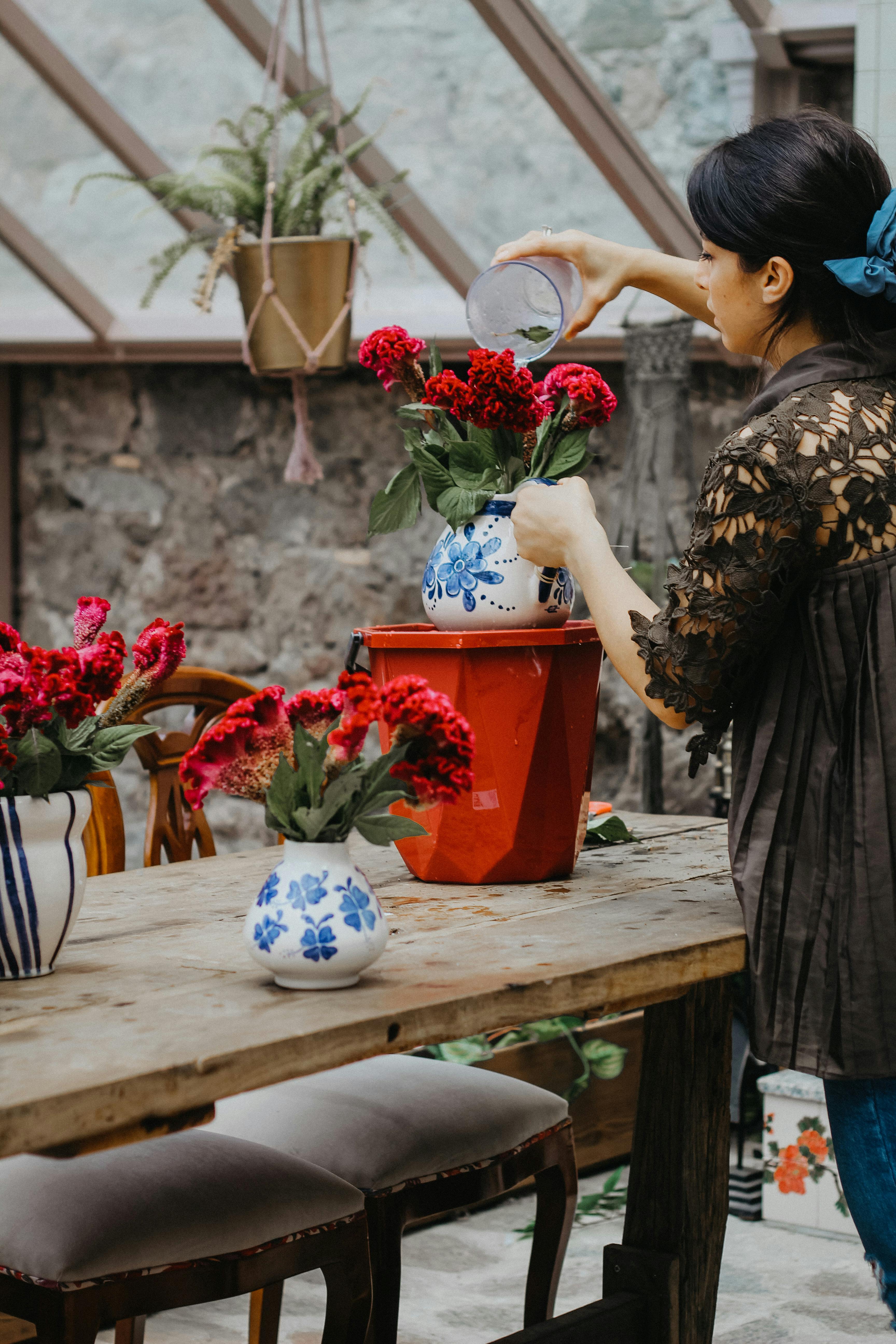 Woman Pouring Water in a Flower Vase · Free Stock Photo