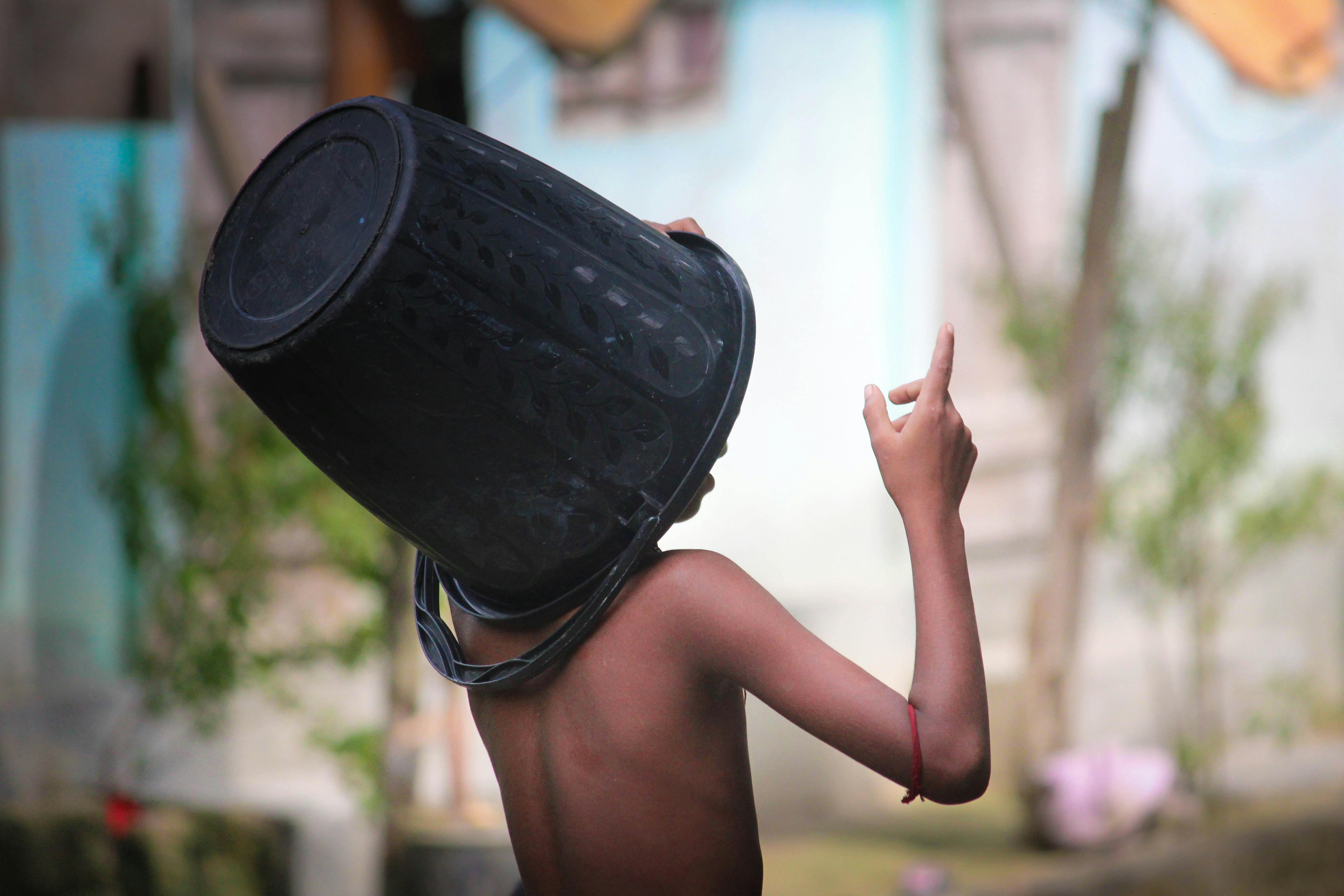 Woman Putting Fish in a Bucket on the Beach · Free Stock Photo