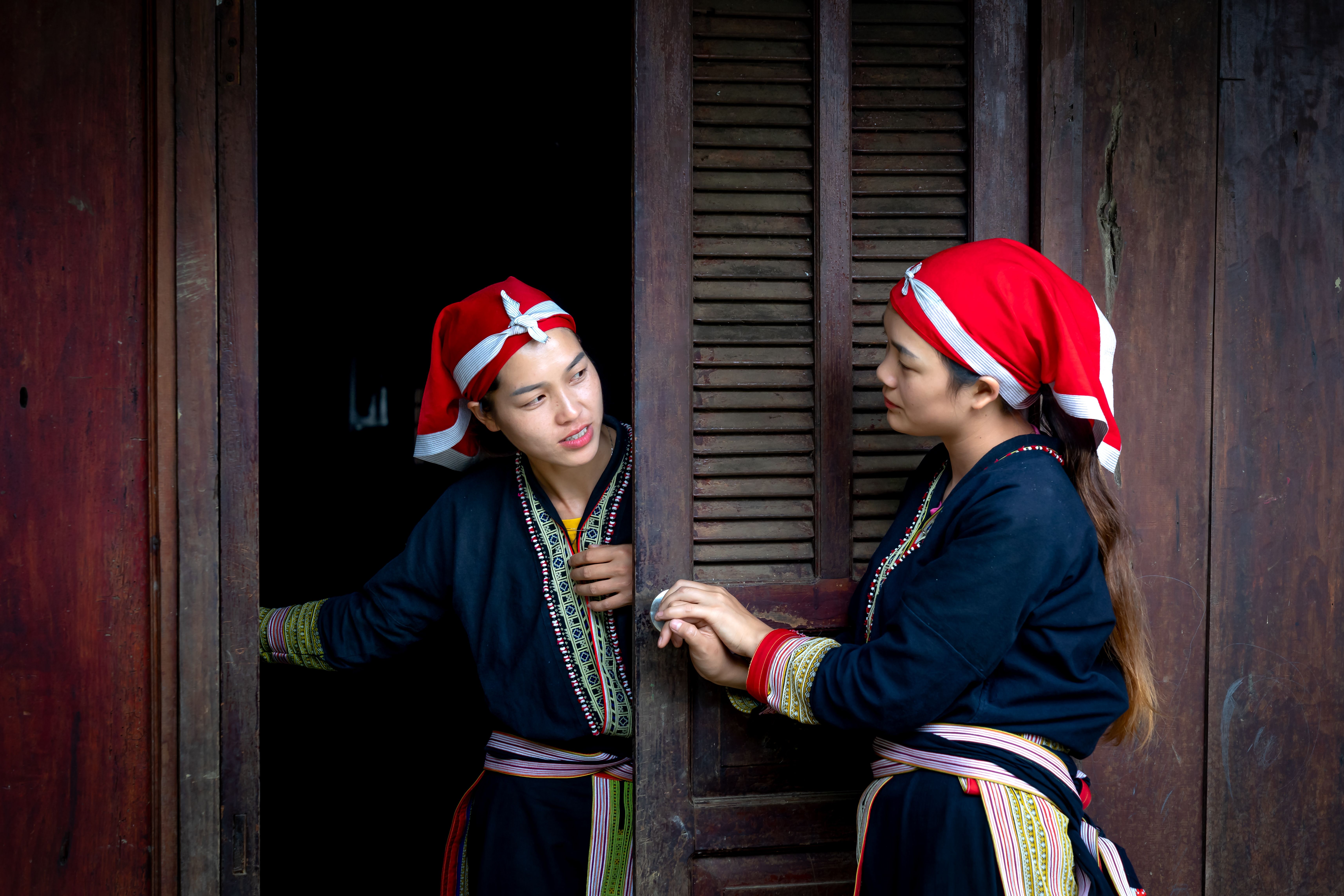 Women in Traditional Clothing Talking Beside a Door · Free Stock Photo