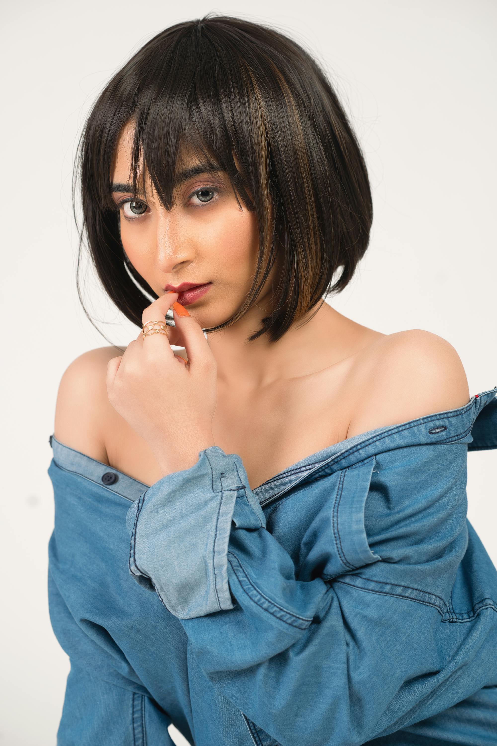 Beautiful Woman in Denim Dress with Hand on Lips · Free Stock Photo
