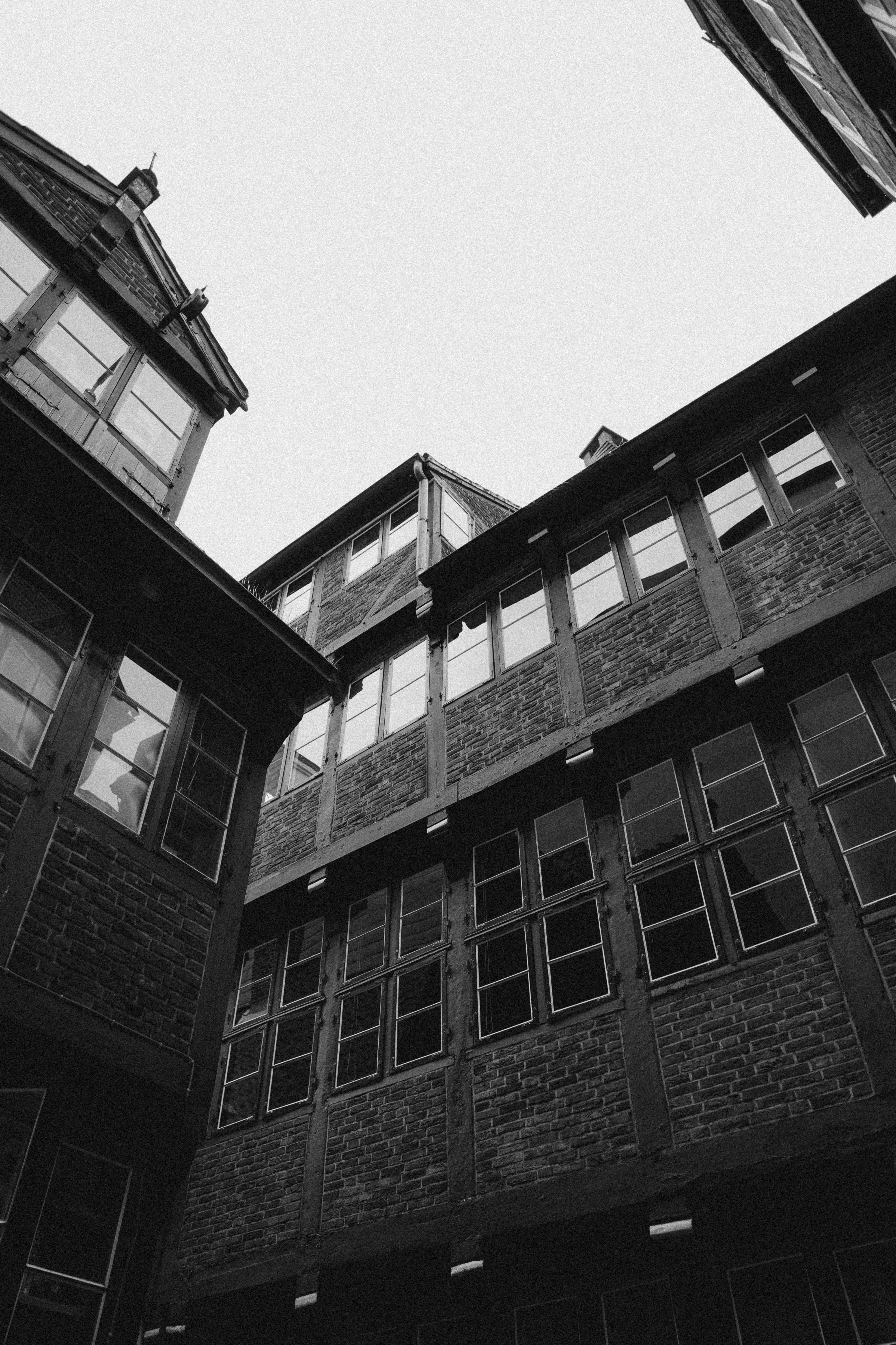 A Grayscale Photo of Concrete Building with Glass Windows · Free Stock ...