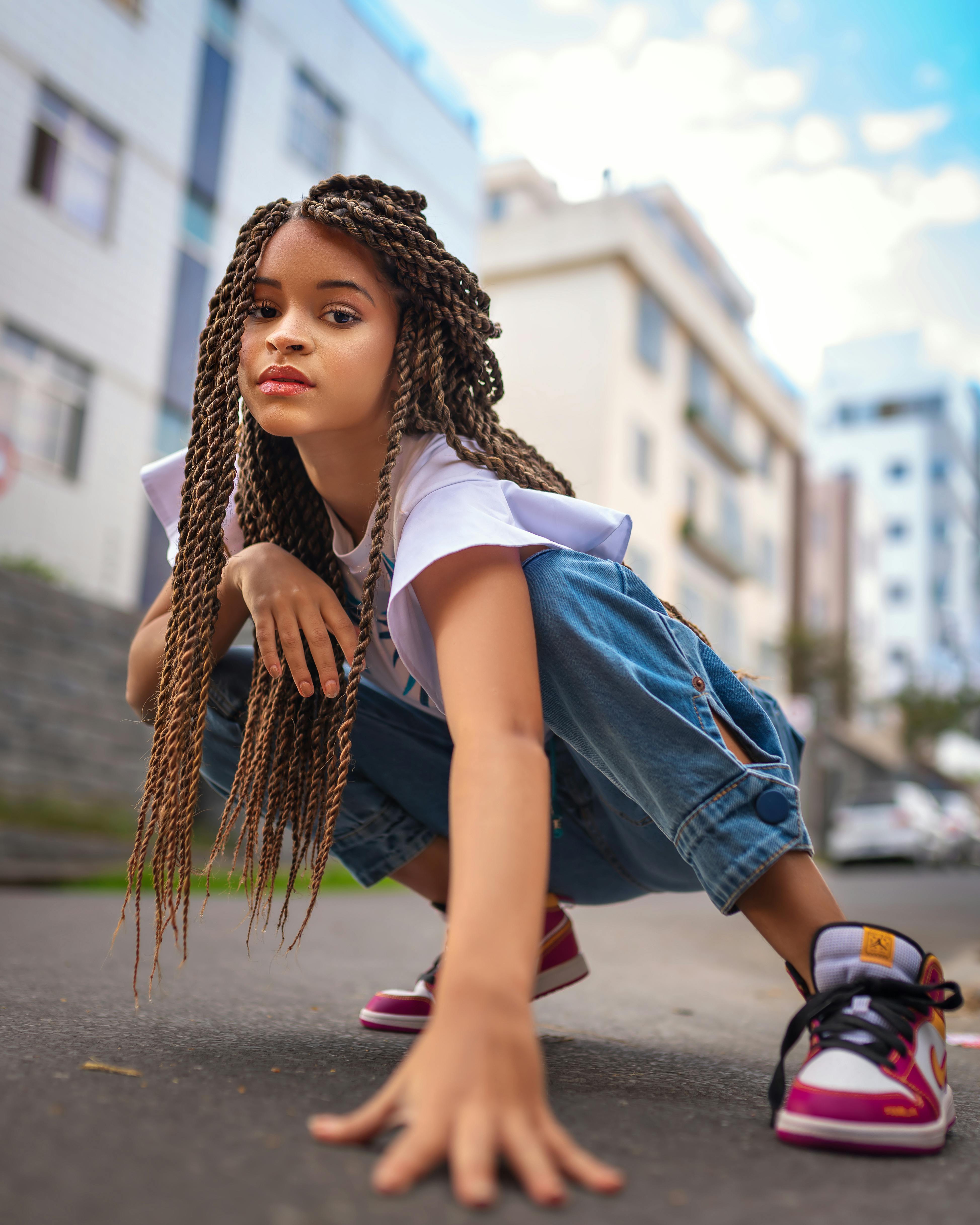 Portrait of Beautiful Woman Crouching on City Street · Free Stock Photo