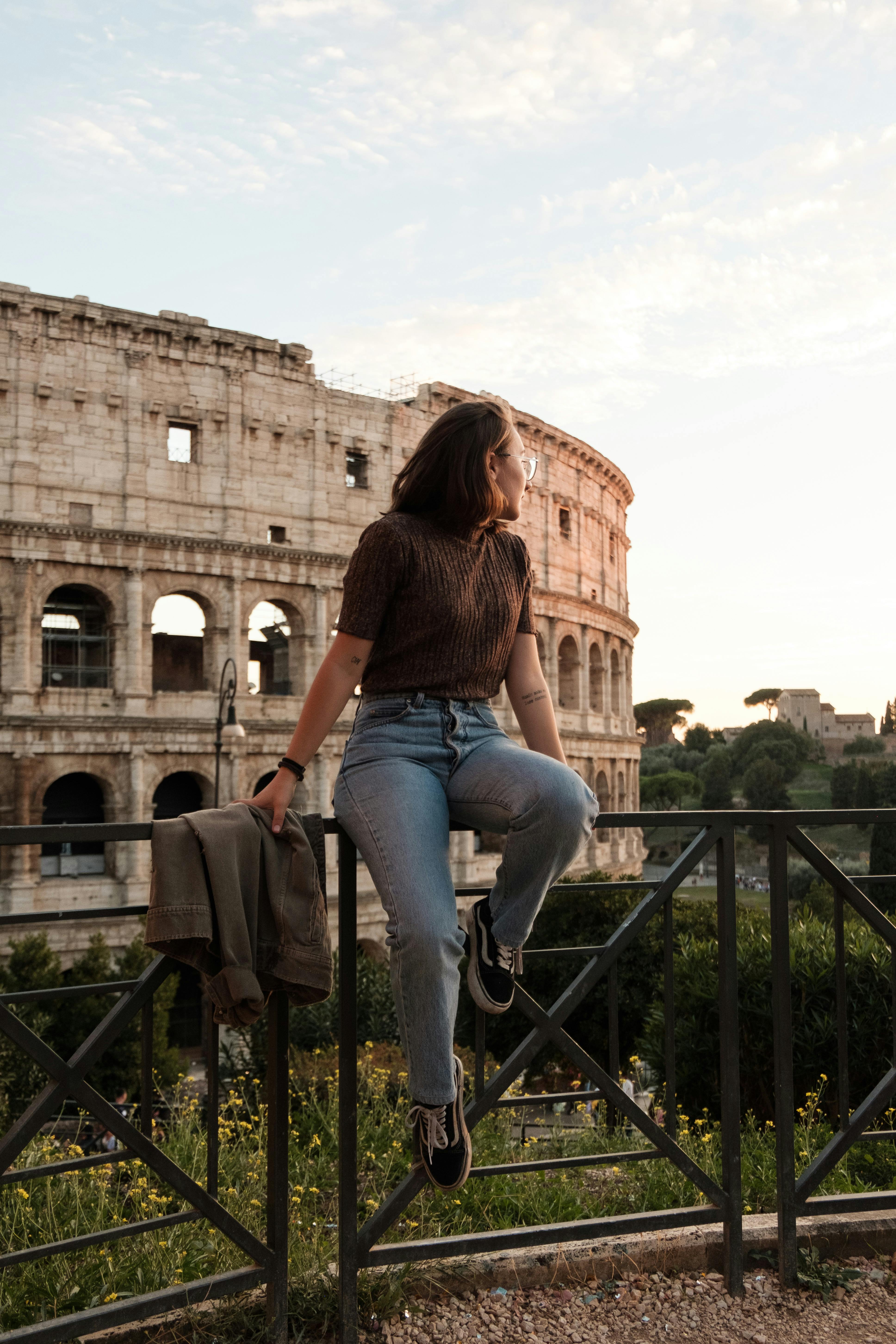 Woman Sitting on Metal Railing · Free Stock Photo