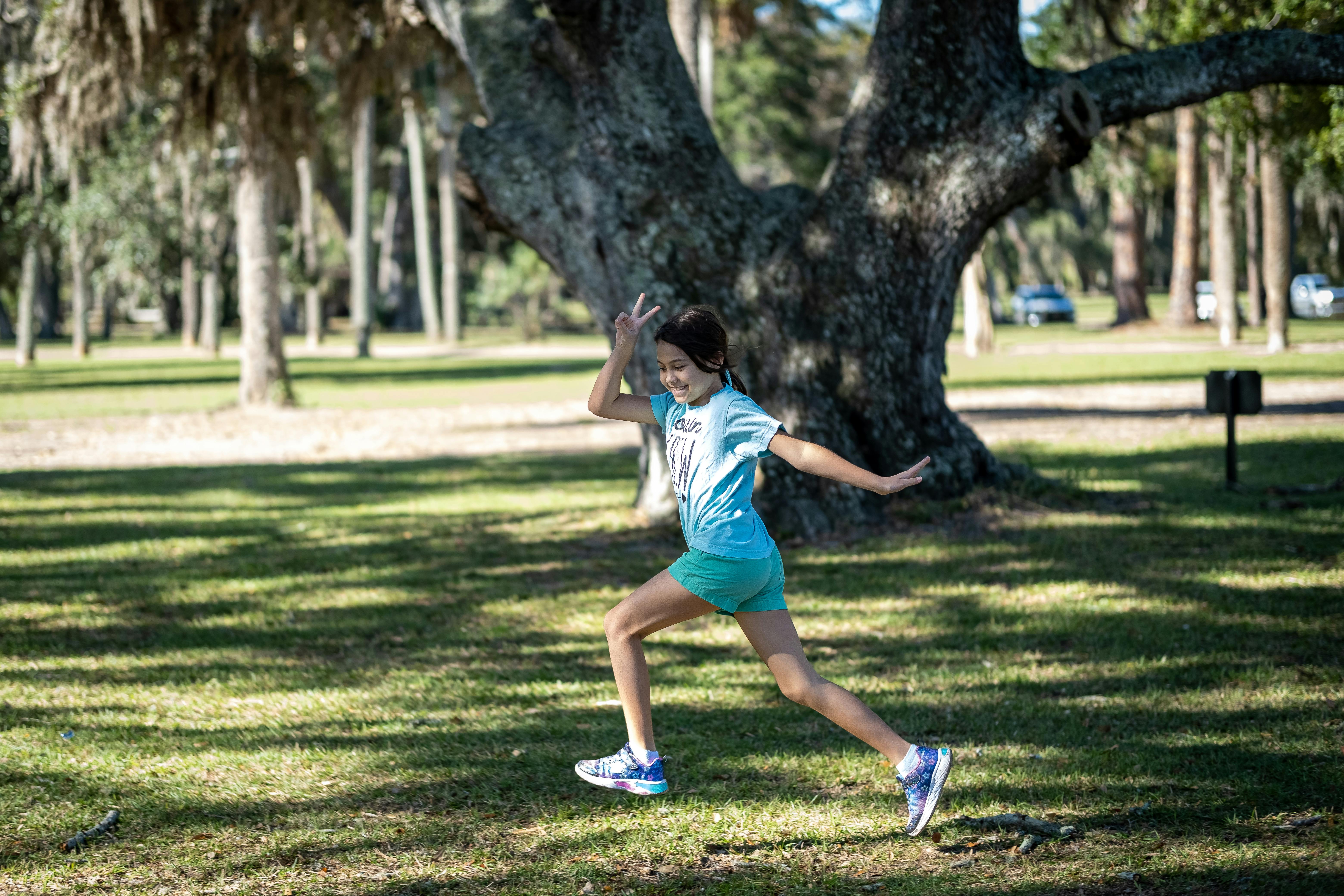 A Girl in a Blue Outfit Running at a Park · Free Stock Photo