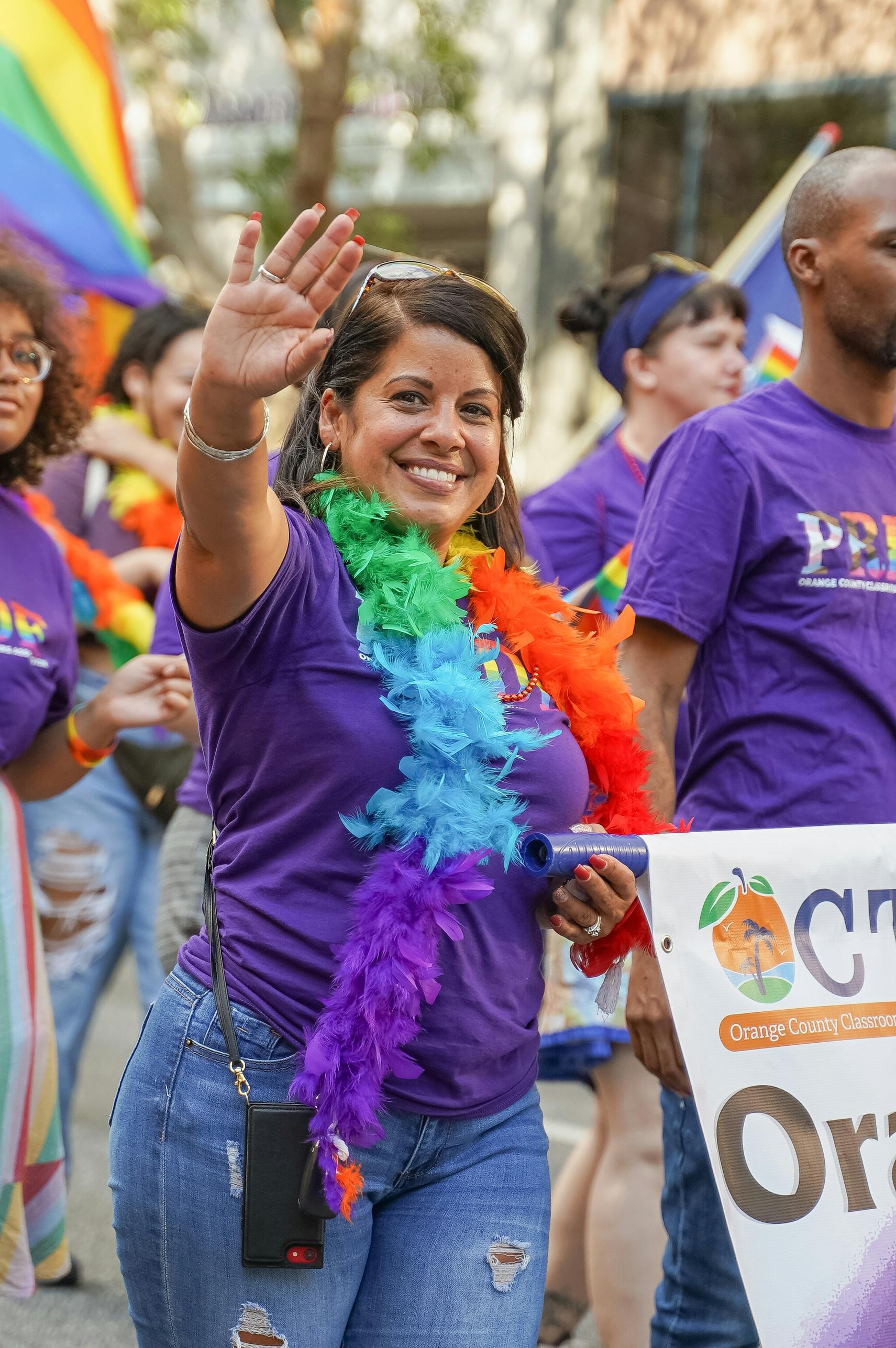 Woman Wearing a Colorful Feather Boa Waving Her Hand · Free Stock Photo