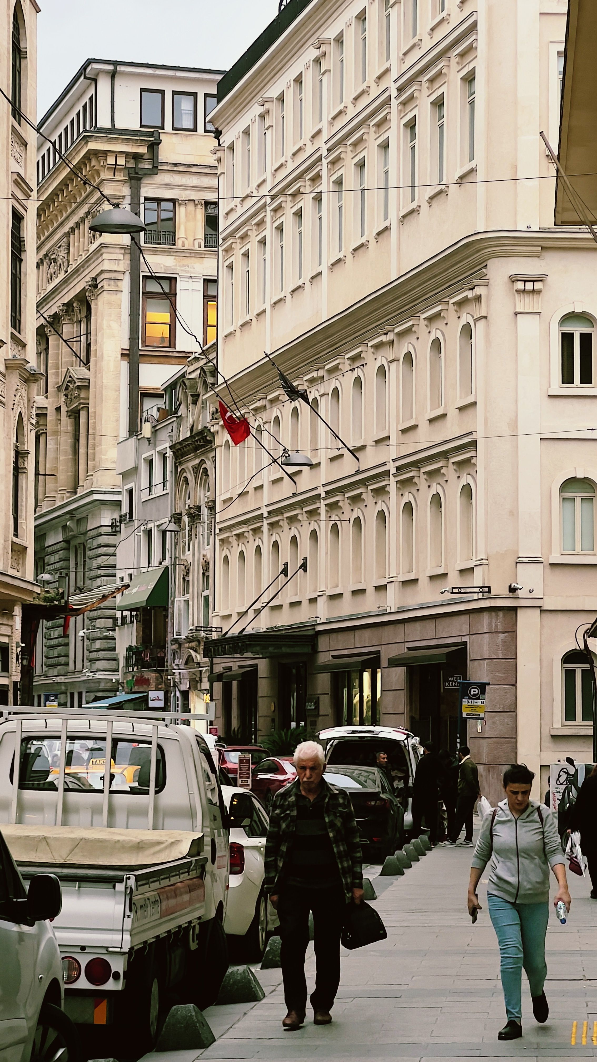 People Walking on the Street Between Concrete Buildings · Free Stock Photo