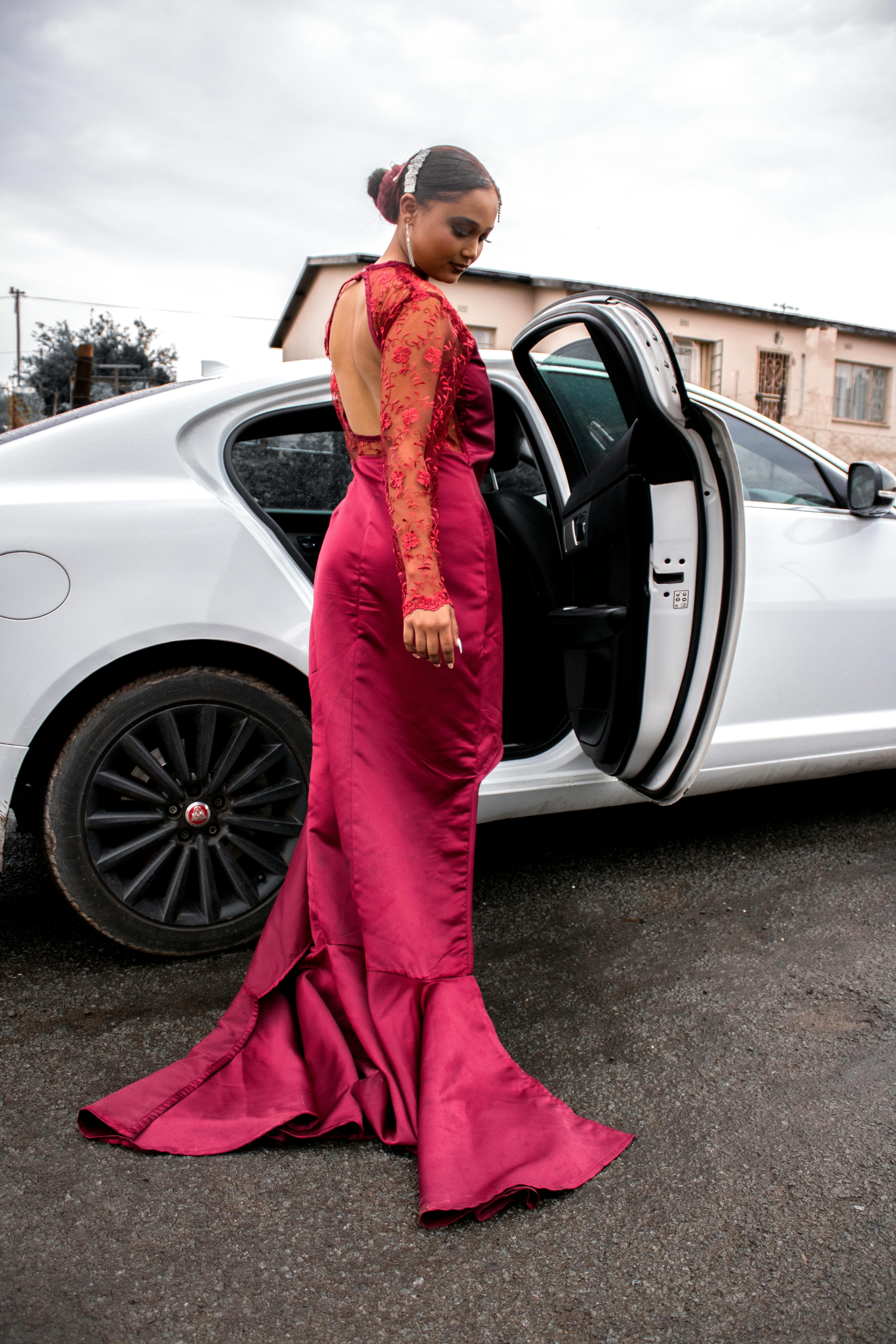 Woman in Long Drees Dress Standing Beside a Car · Free Stock Photo