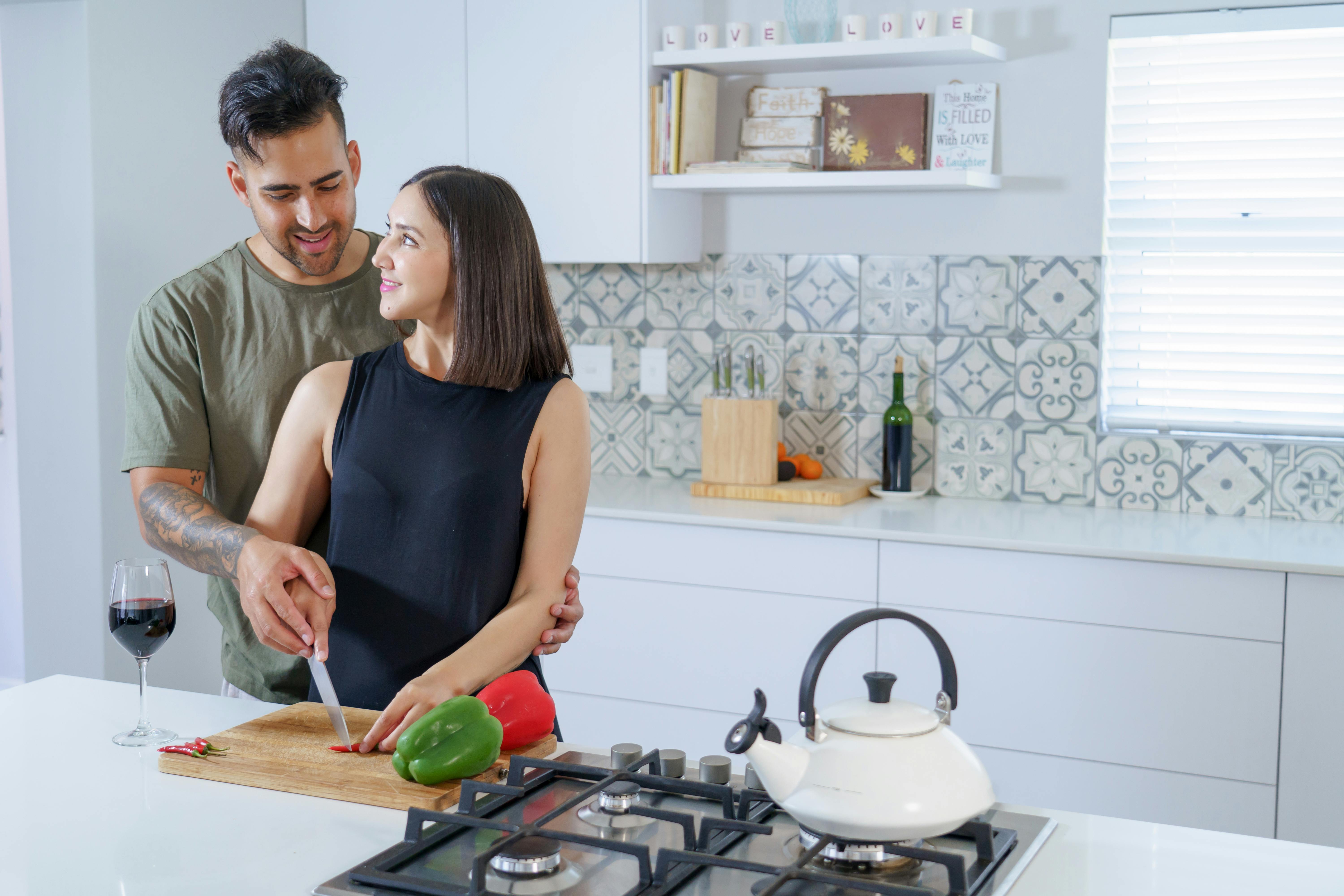 Man and Woman Embracing while Cooking Together · Free Stock Photo