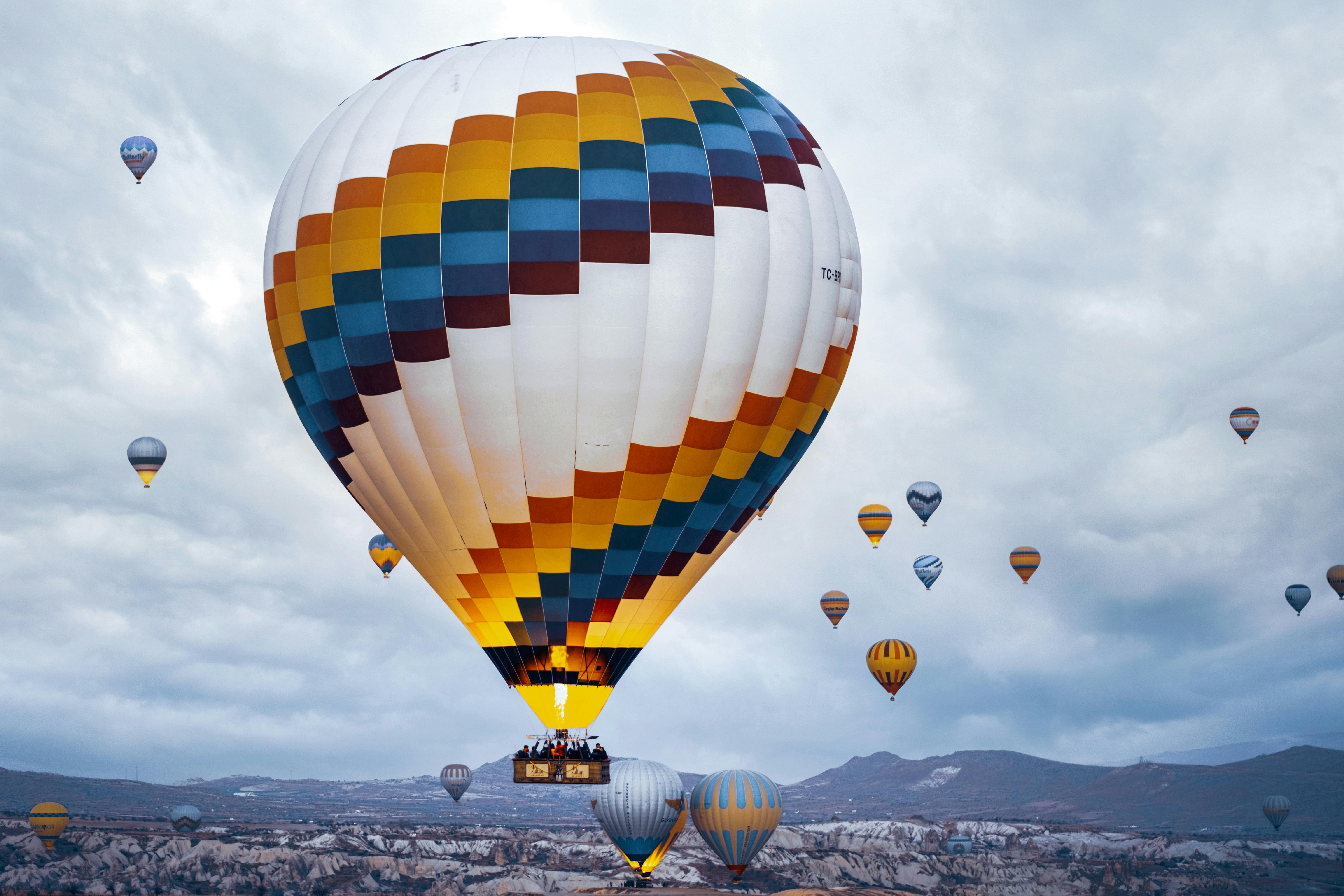 Four Beige Hot Air Balloons Flying · Free Stock Photo