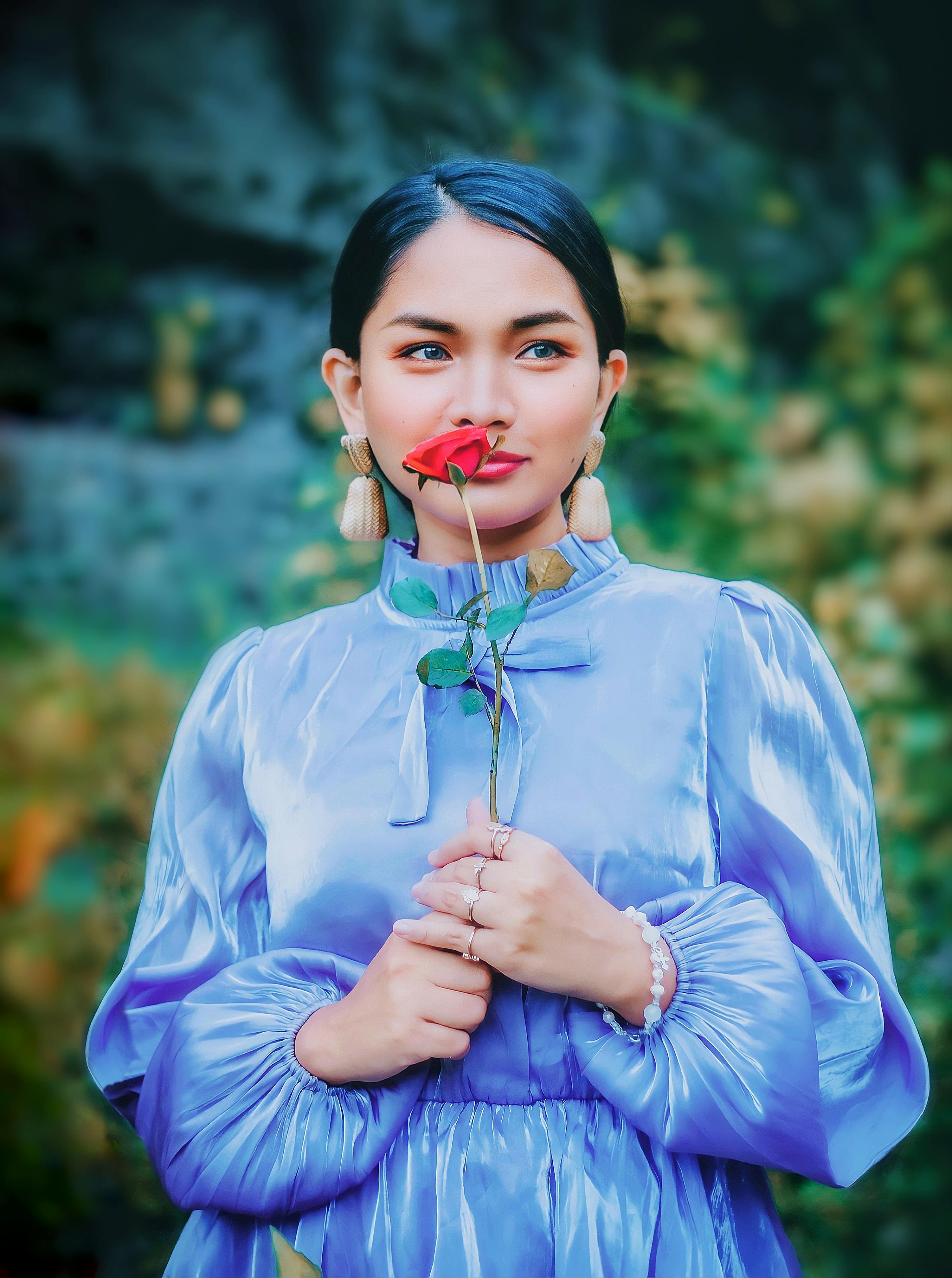 Woman in Blue Long Sleeve Dress Holding a Rose · Free Stock Photo