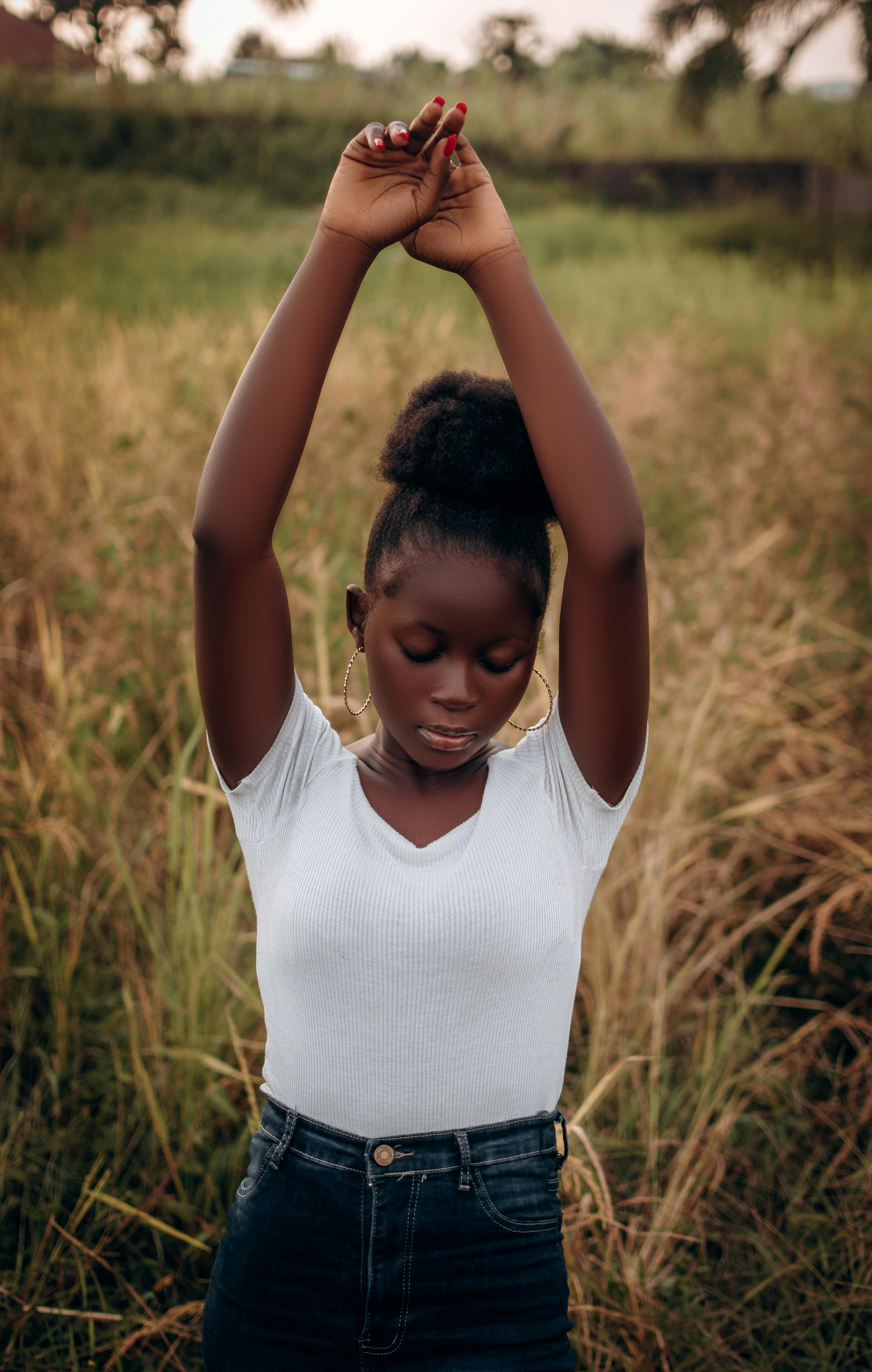 Woman Standing with Arms Raised on Grassland · Free Stock Photo