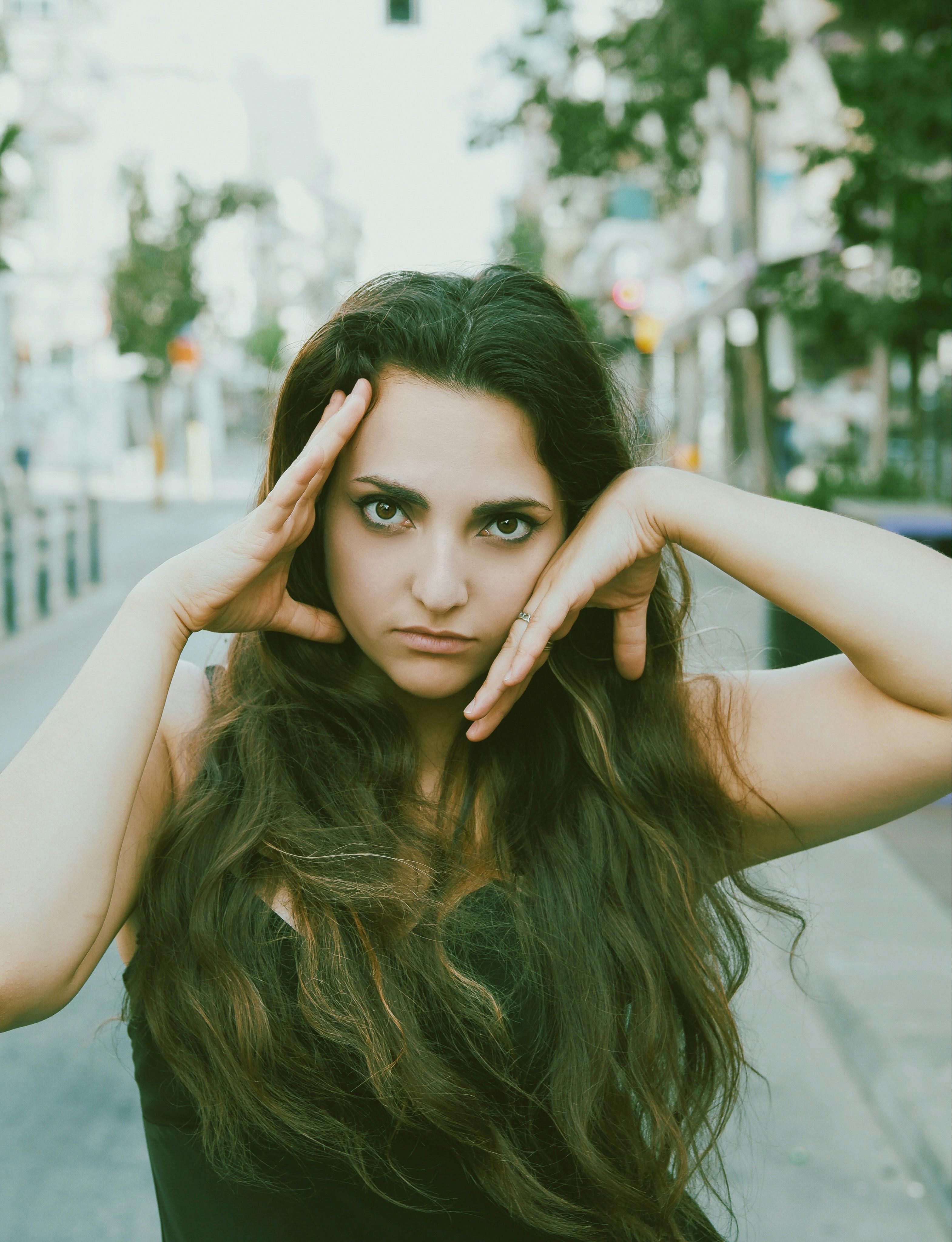 Portrait of a Woman Posing with Her Hands on Her Face · Free Stock Photo