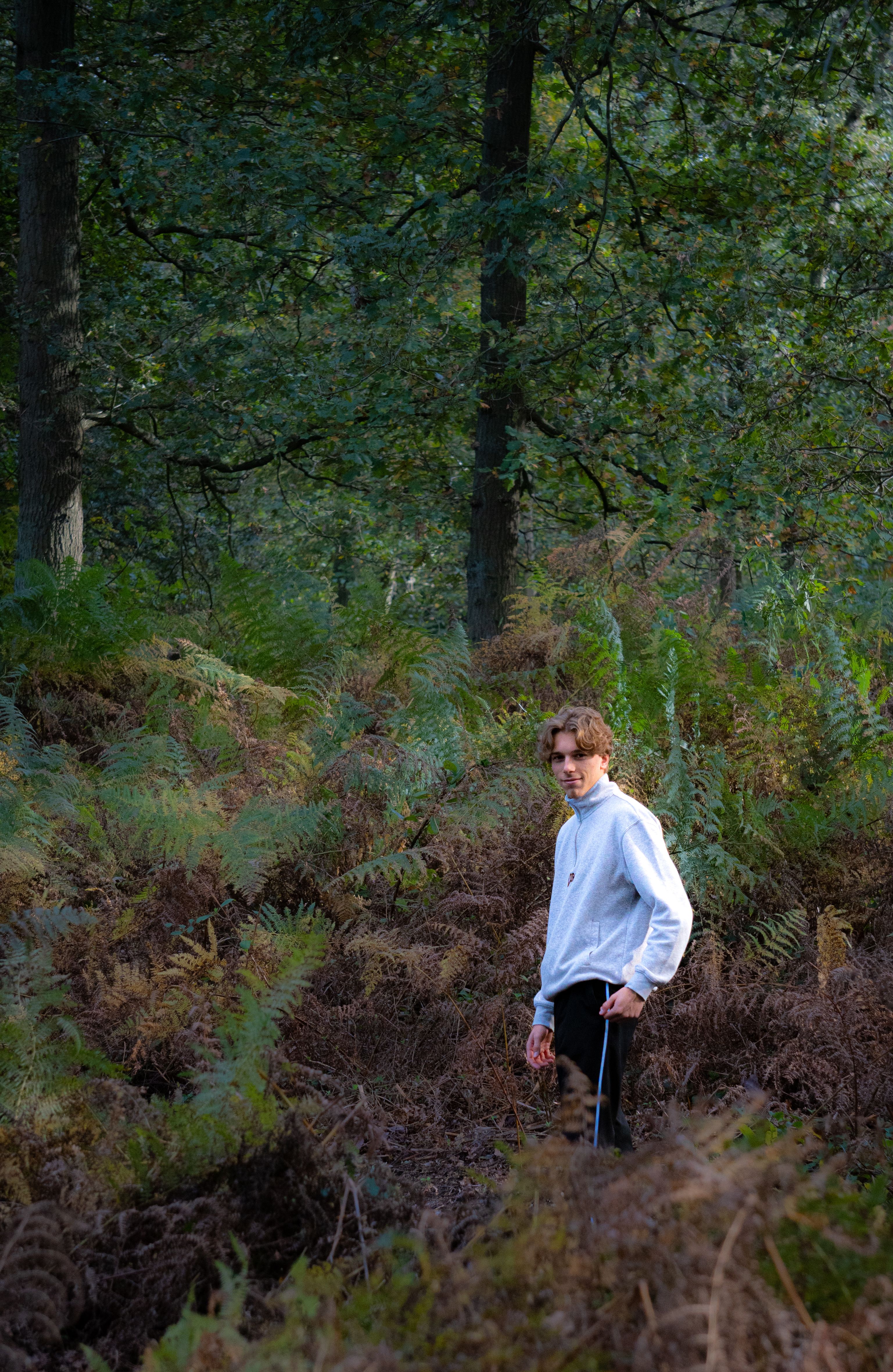 Man Standing among Bushes in Forest · Free Stock Photo