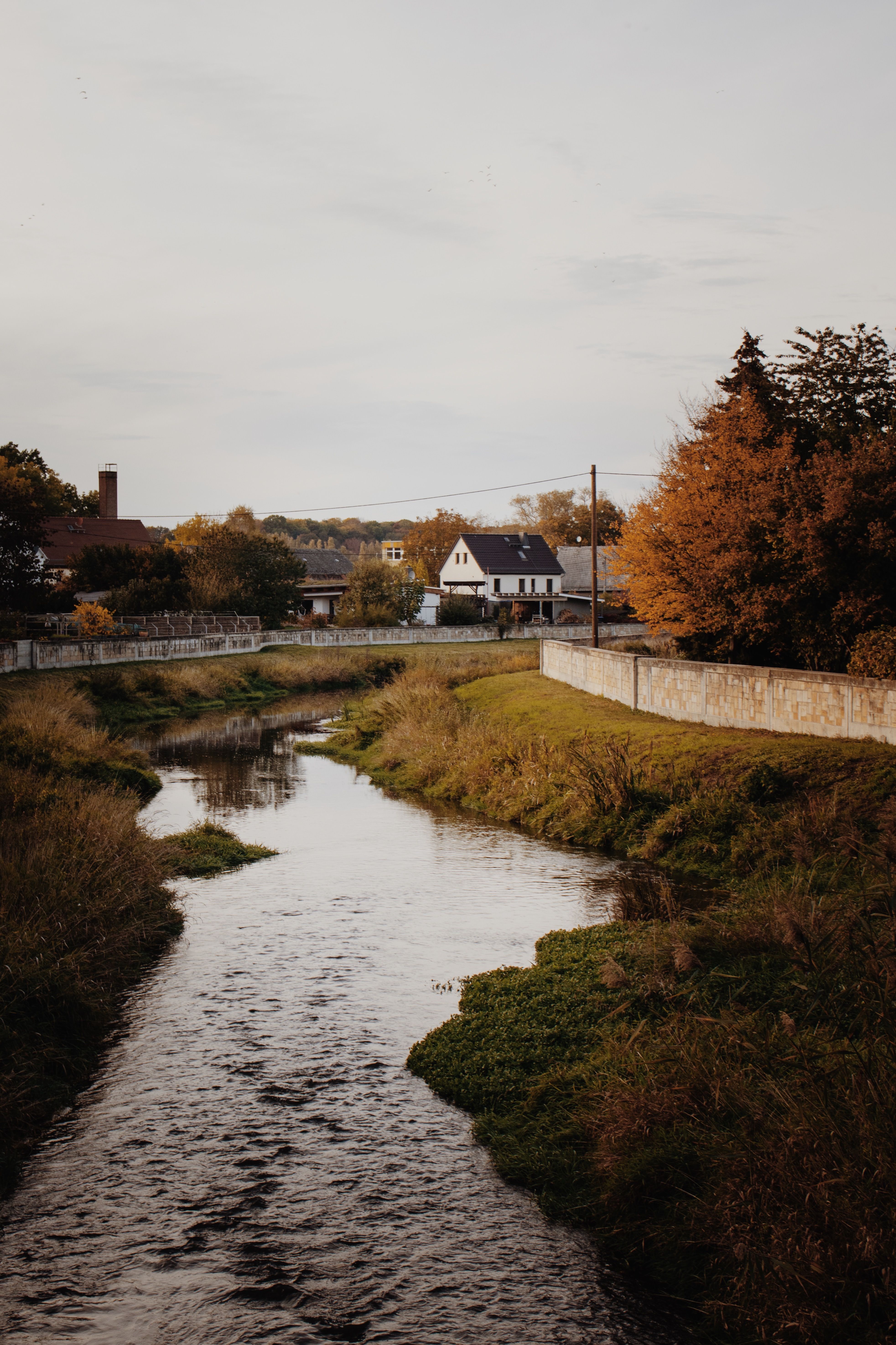 River Flowing at Dam in Town Landscape · Free Stock Photo