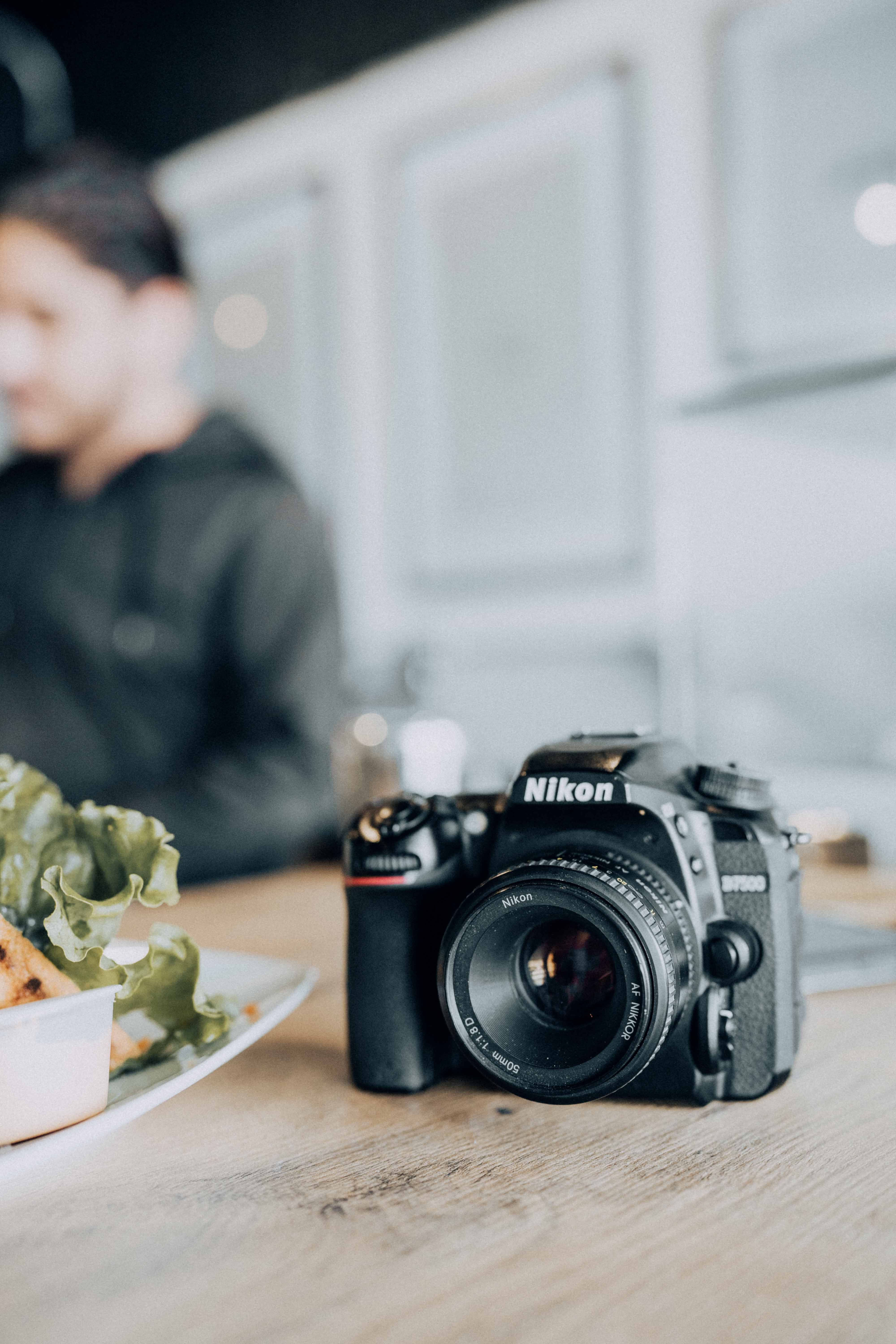 A Nikon Camera on the Wooden Table · Free Stock Photo