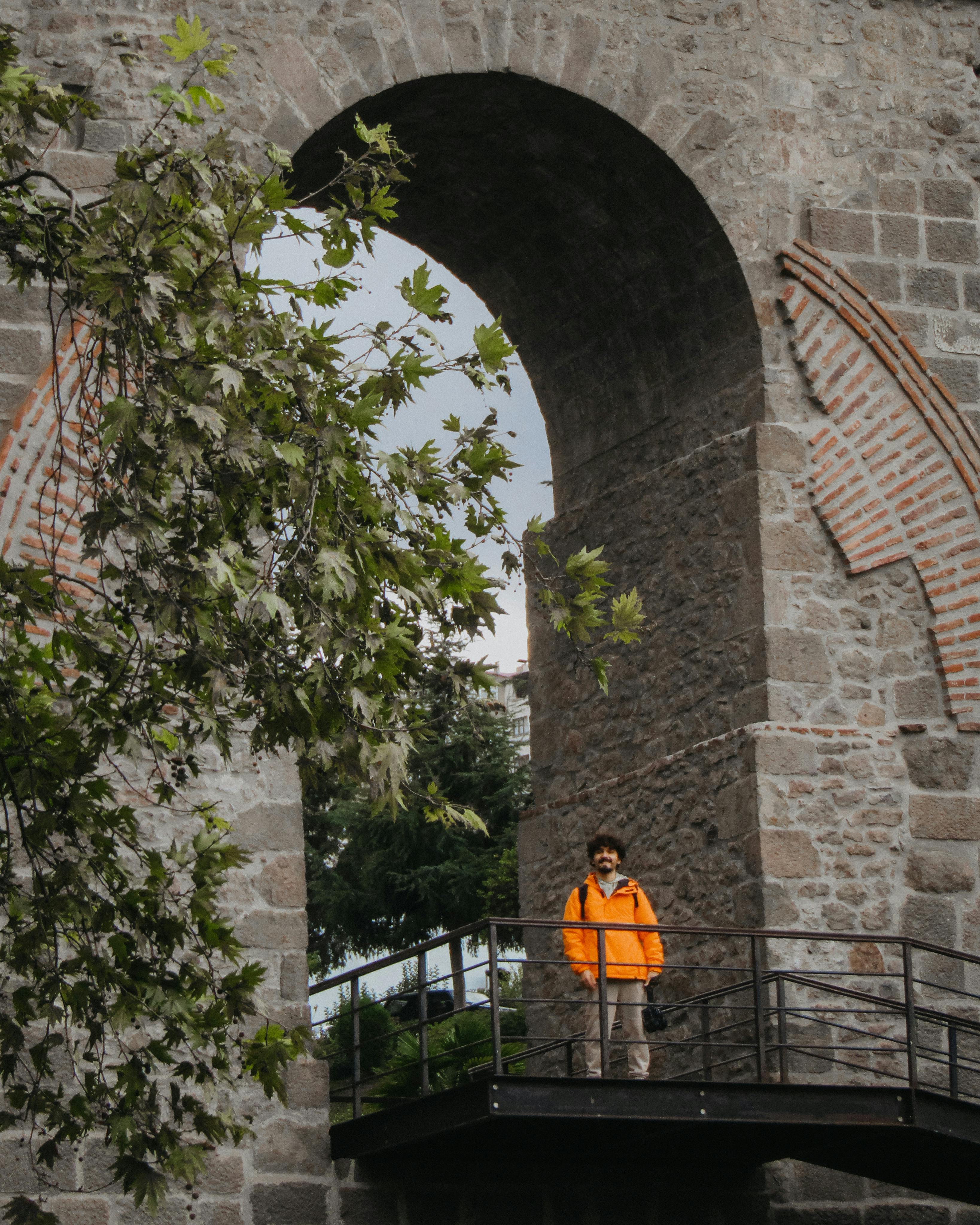 Man Standing on Bridge near Brick Castle Arch · Free Stock Photo
