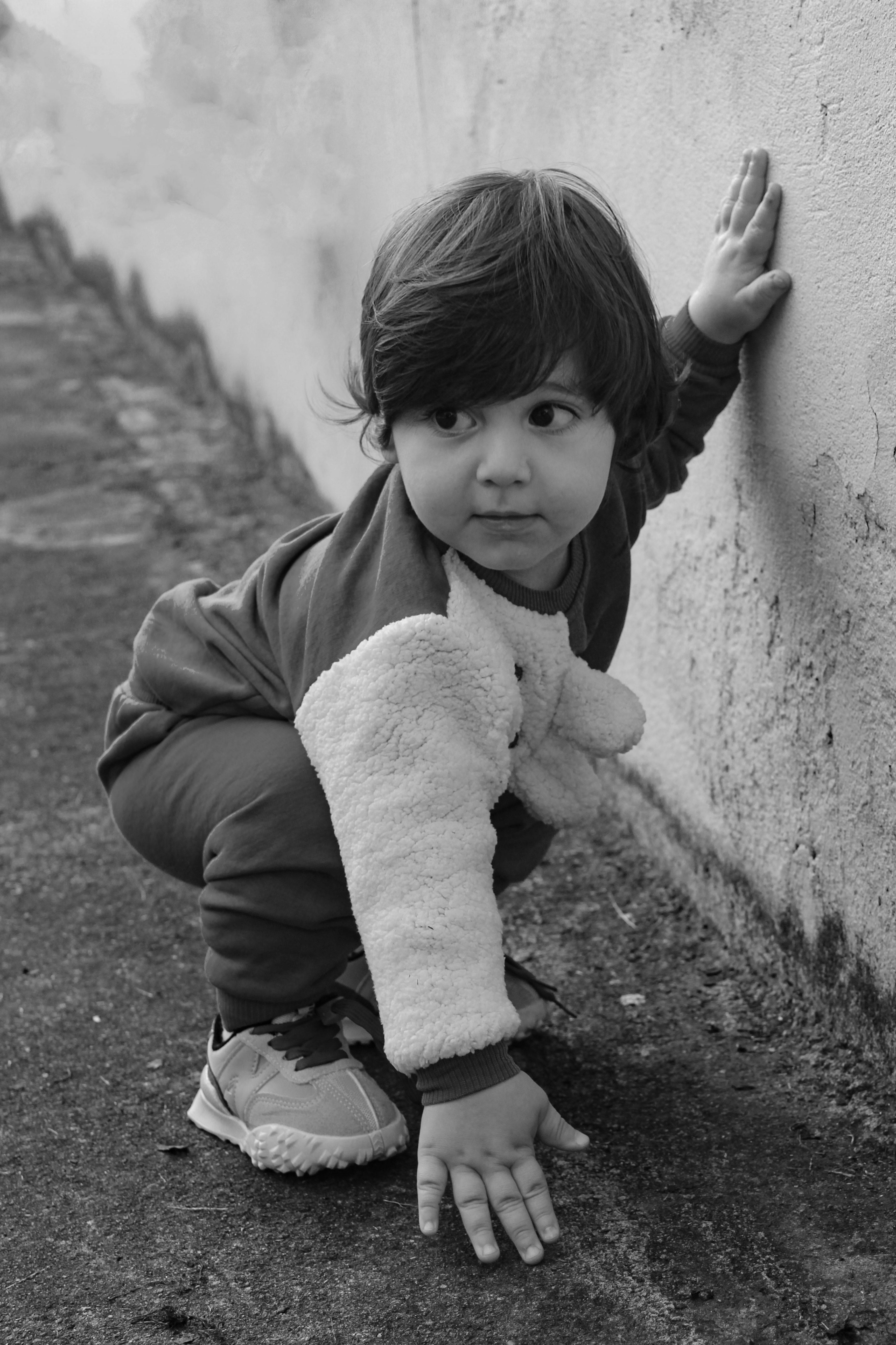 Black and White Photo of a Crouching Child · Free Stock Photo