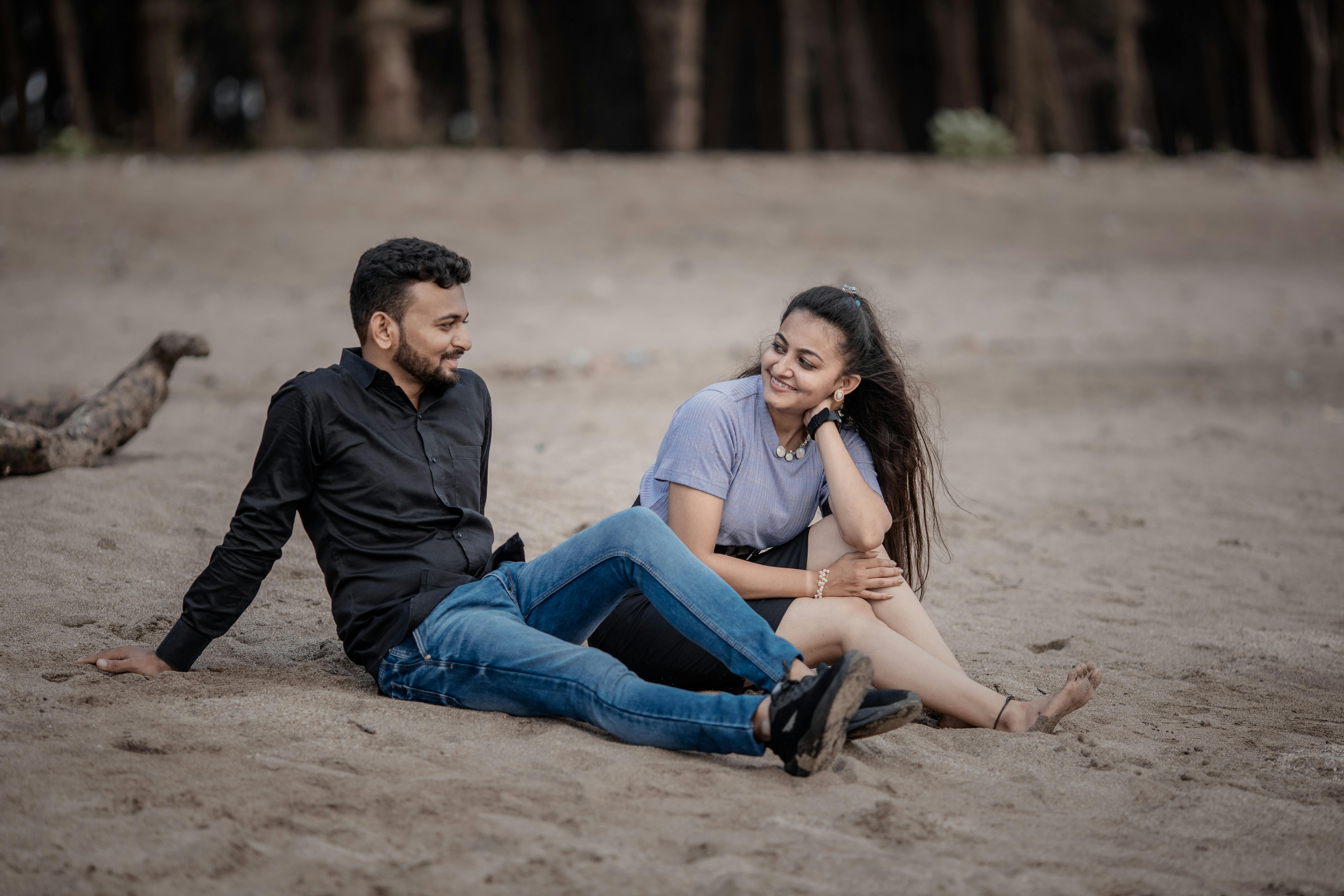 Man and a Woman Sitting on Sand · Free Stock Photo