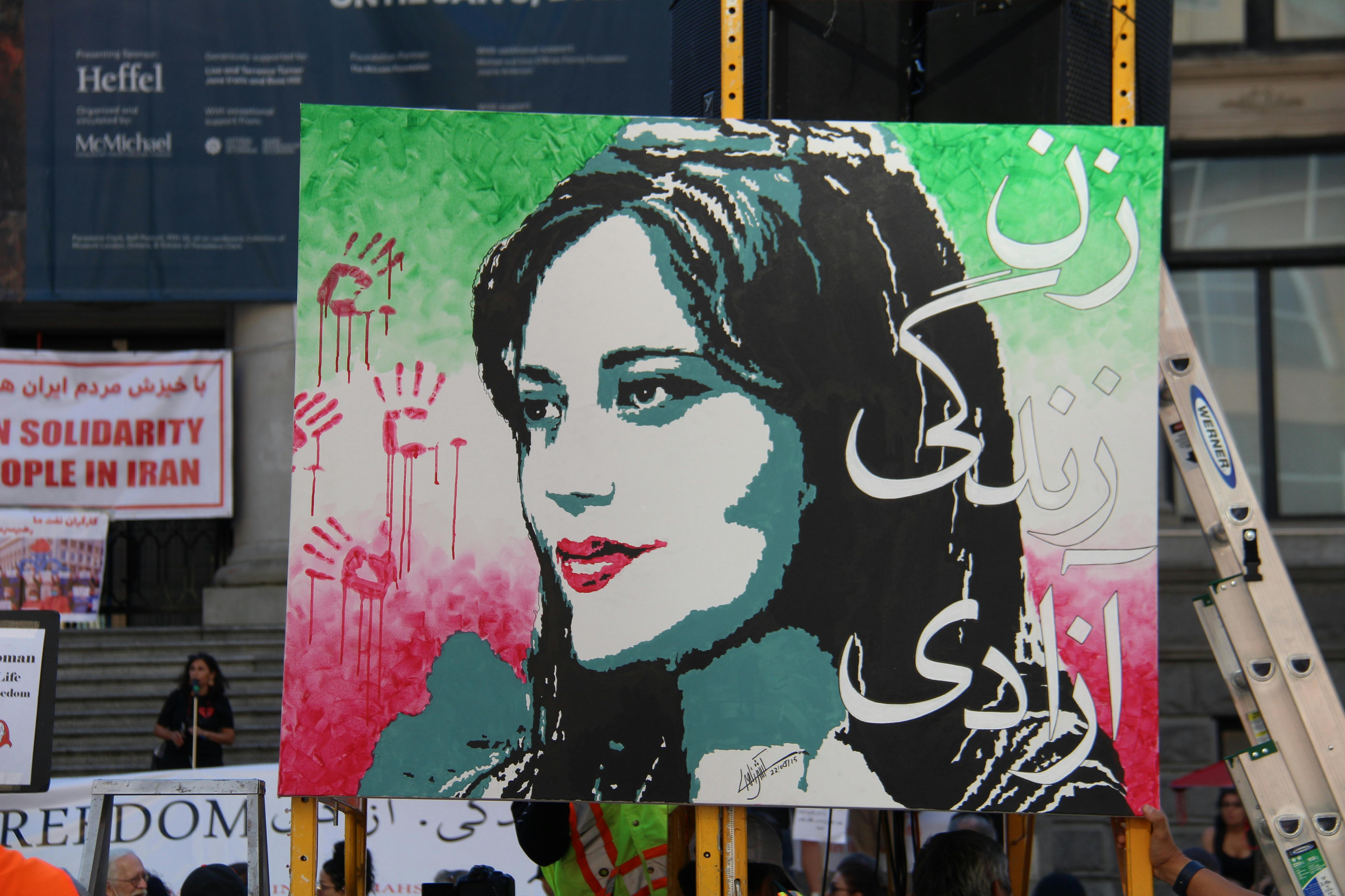 A Painting of a Woman with Arabic Calligraphy in a Rally · Free Stock Photo