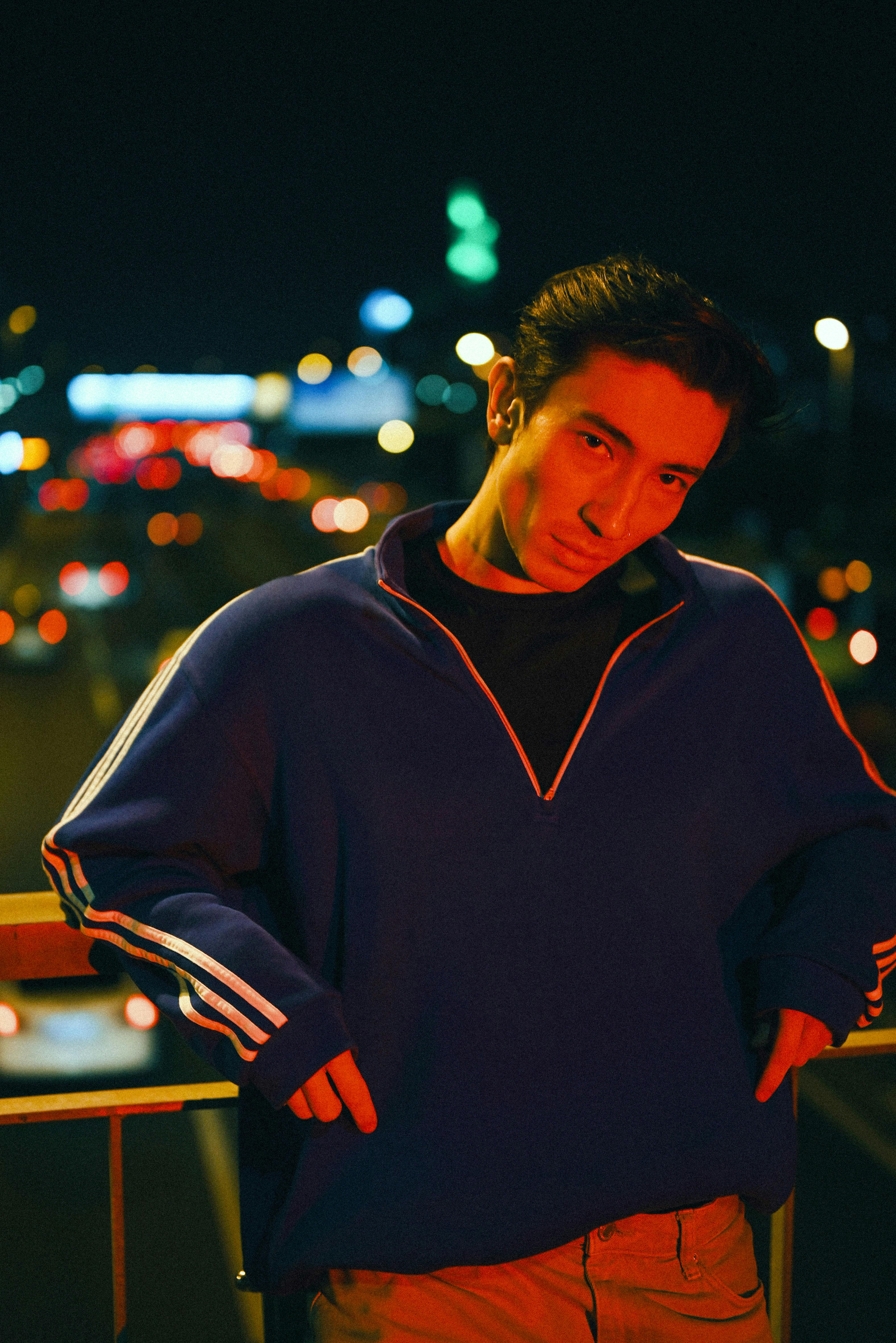 Man Wearing a Blue Jacket Posing on a Bridge · Free Stock Photo