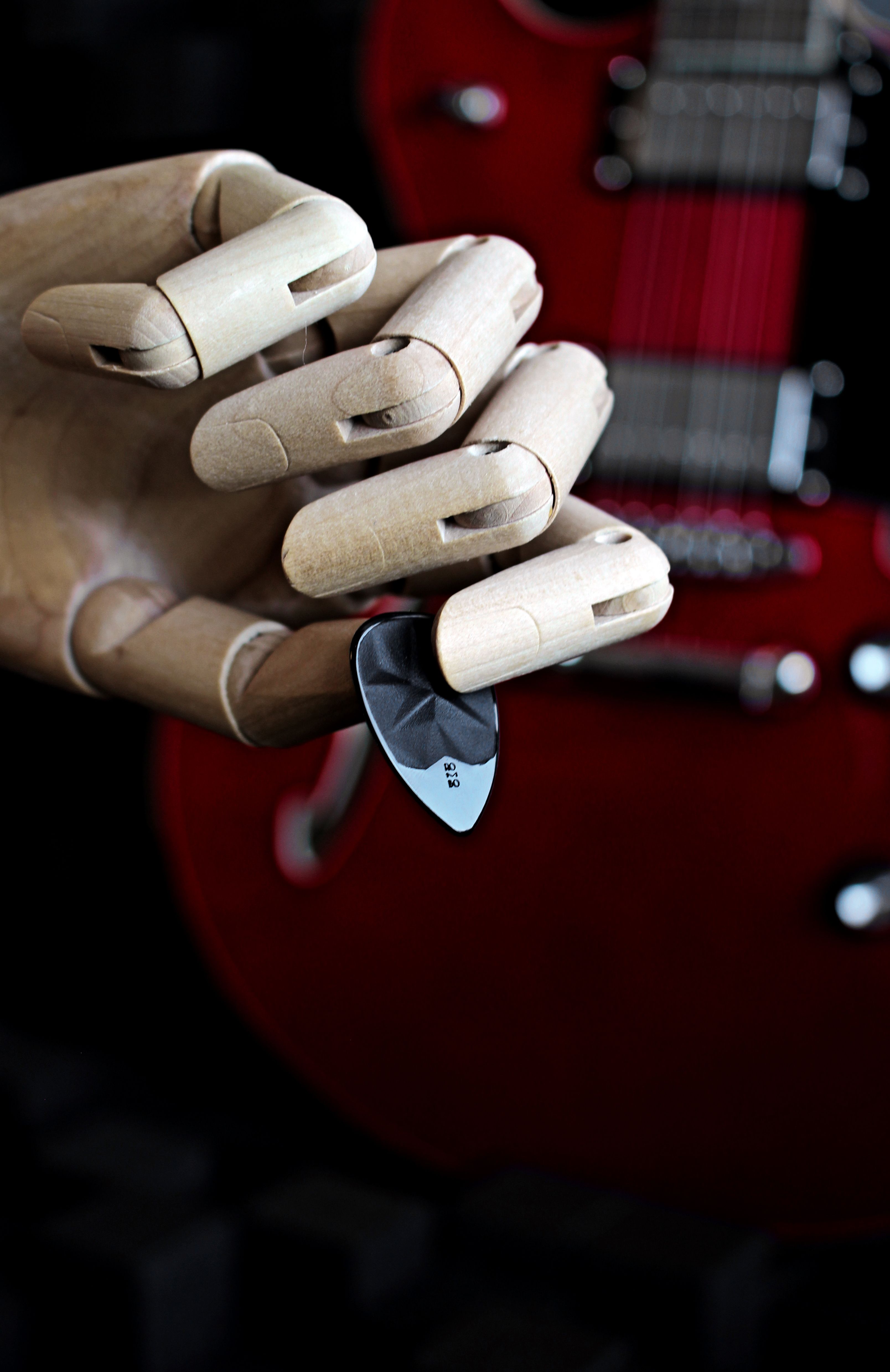 Wooden Hand Holding a Guitar Pick · Free Stock Photo