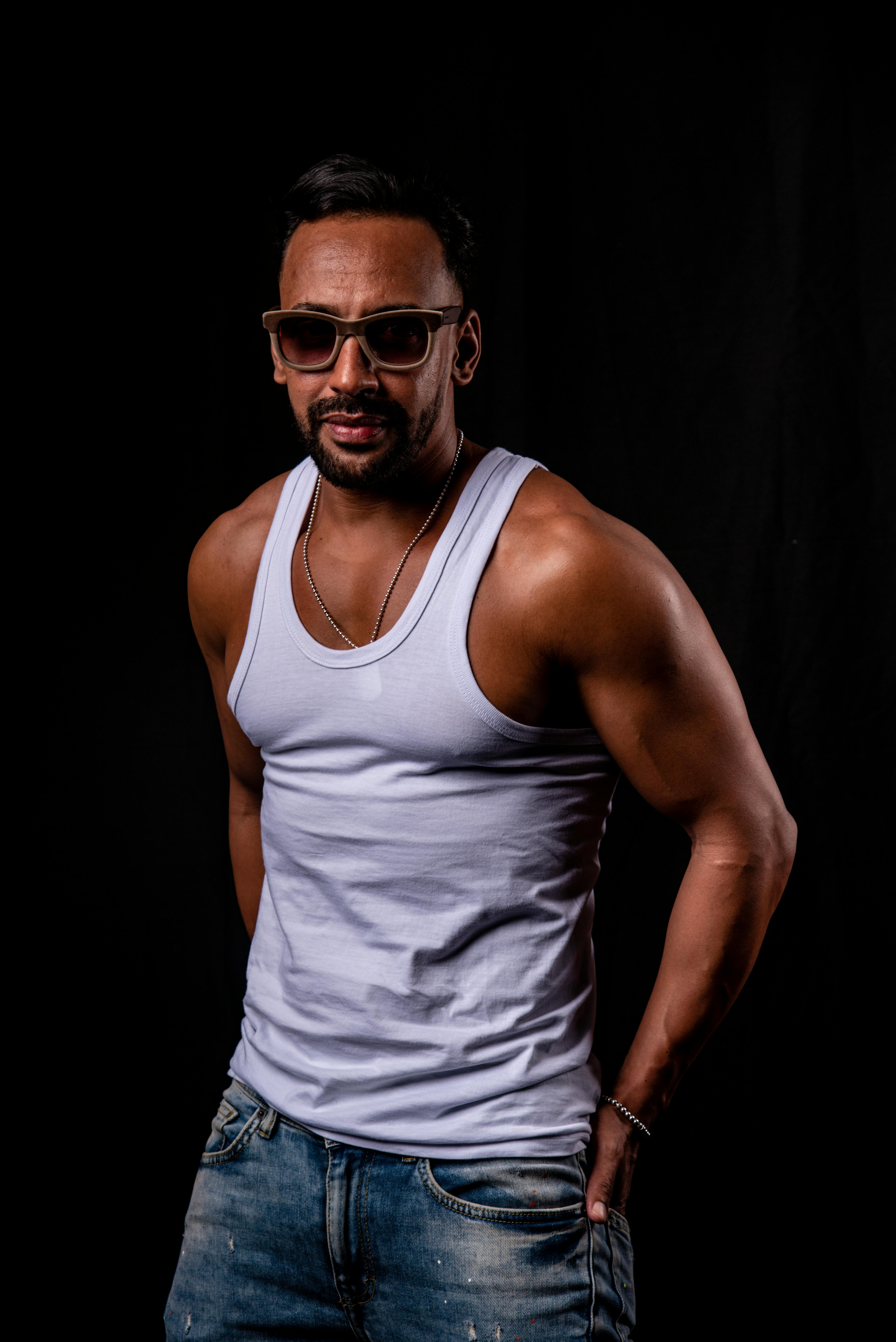 A Man in White Tank Top Wearing Sunglasses · Free Stock Photo