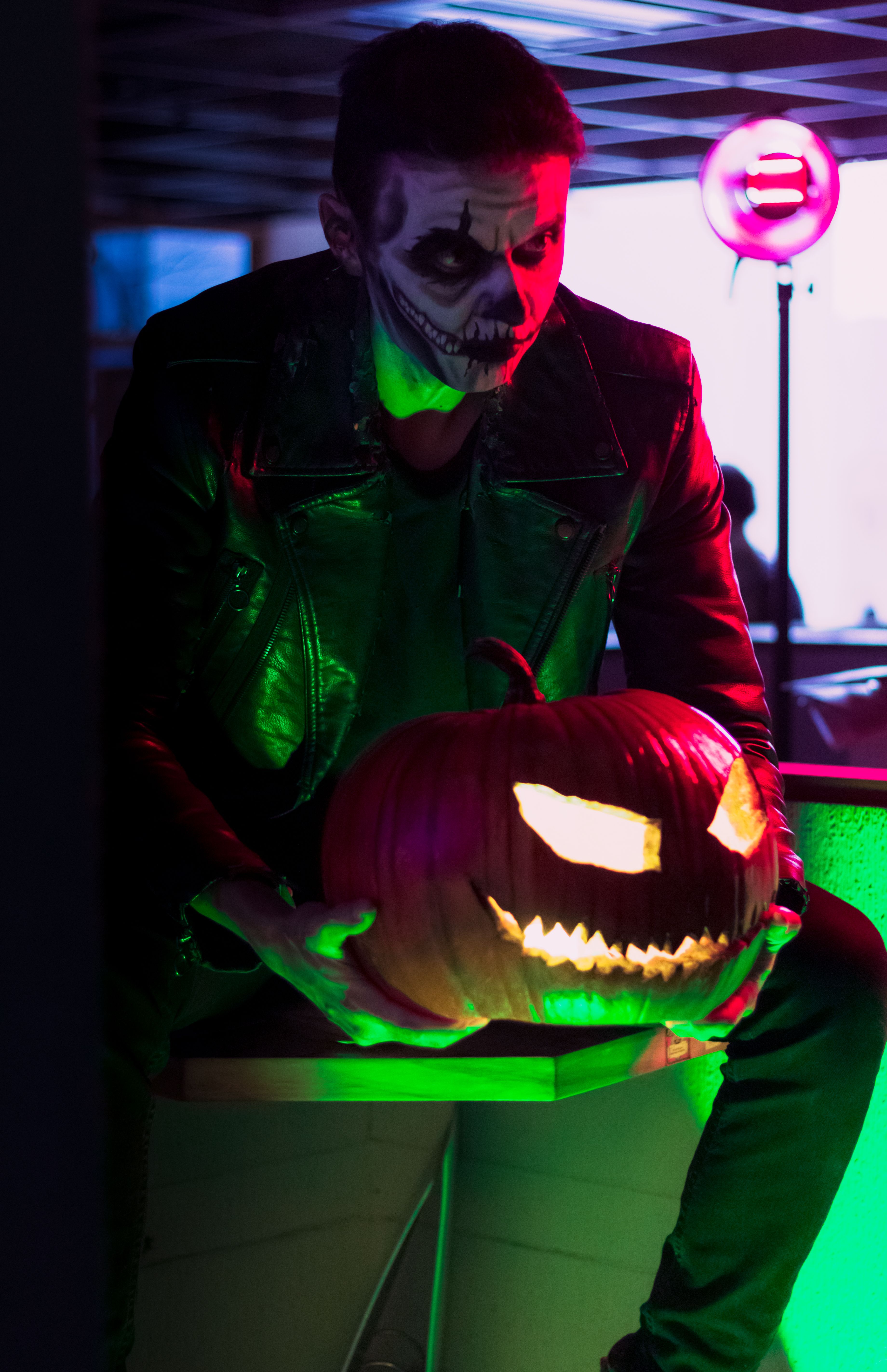 Man in Leather Jacket Holding a Jack O Lantern · Free Stock Photo