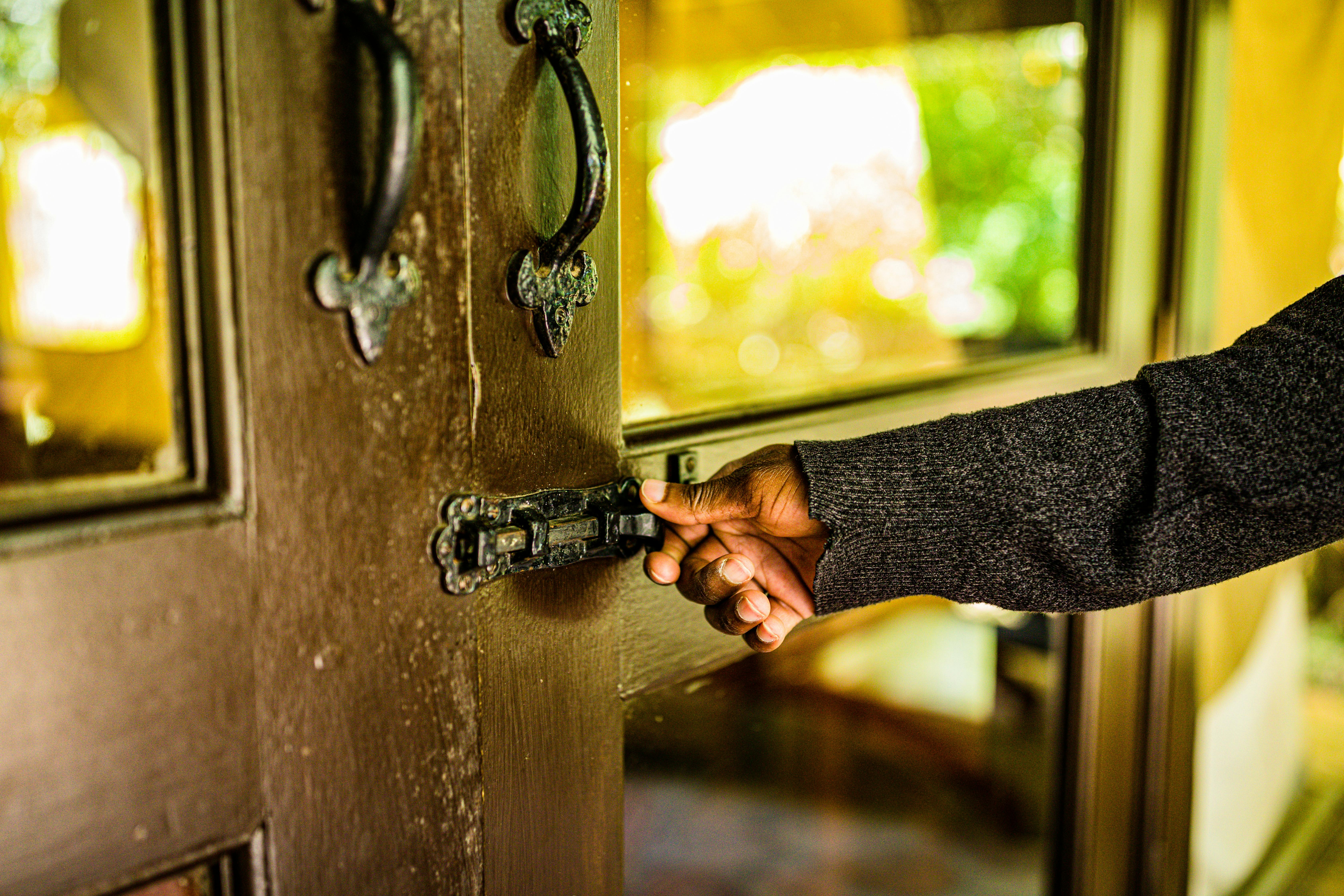 Old Man Hand Touching Lock on Wooden Door · Free Stock Photo