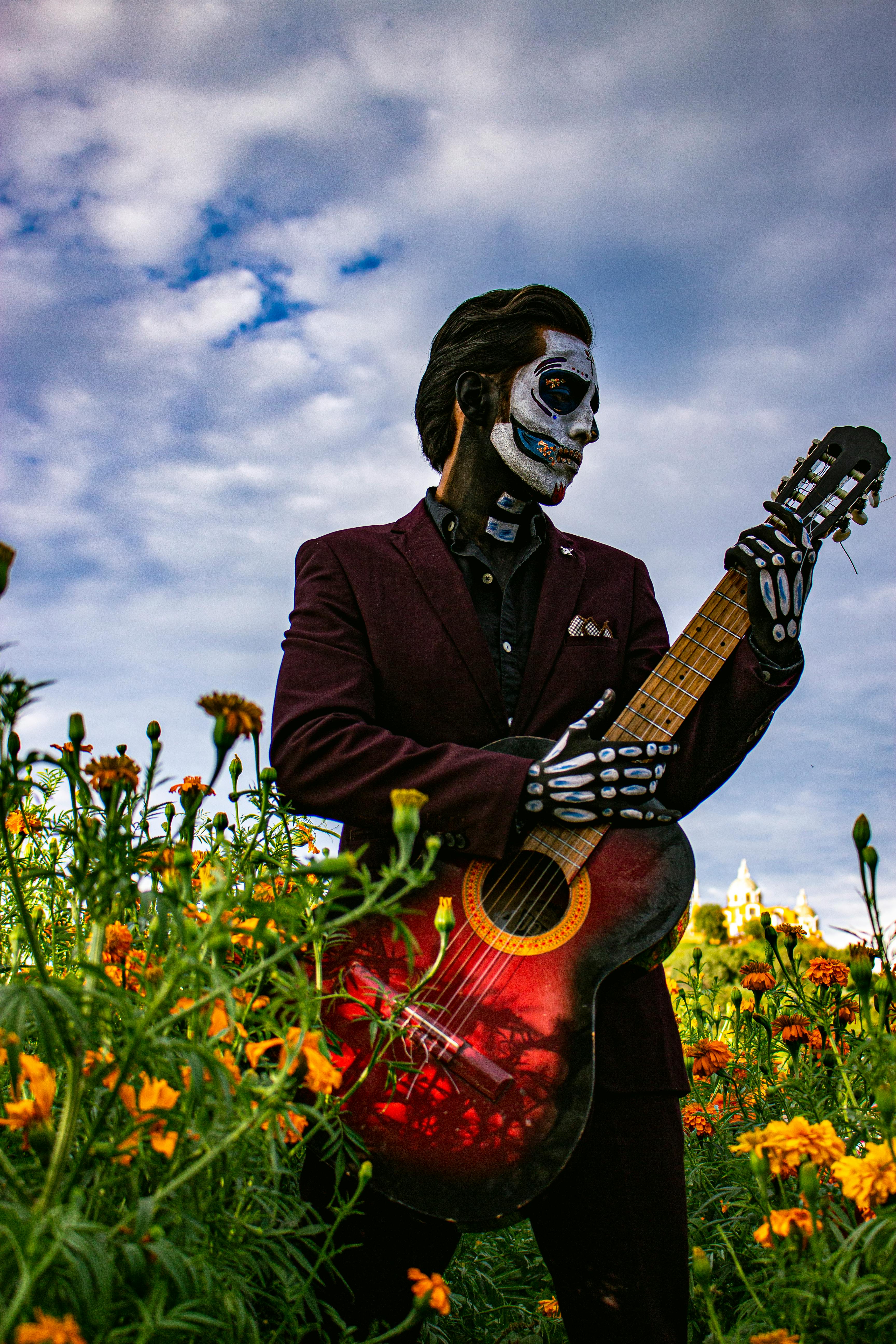 A Man in Maroon Suit Jacket Holding an Acoustic Guitar · Free Stock Photo