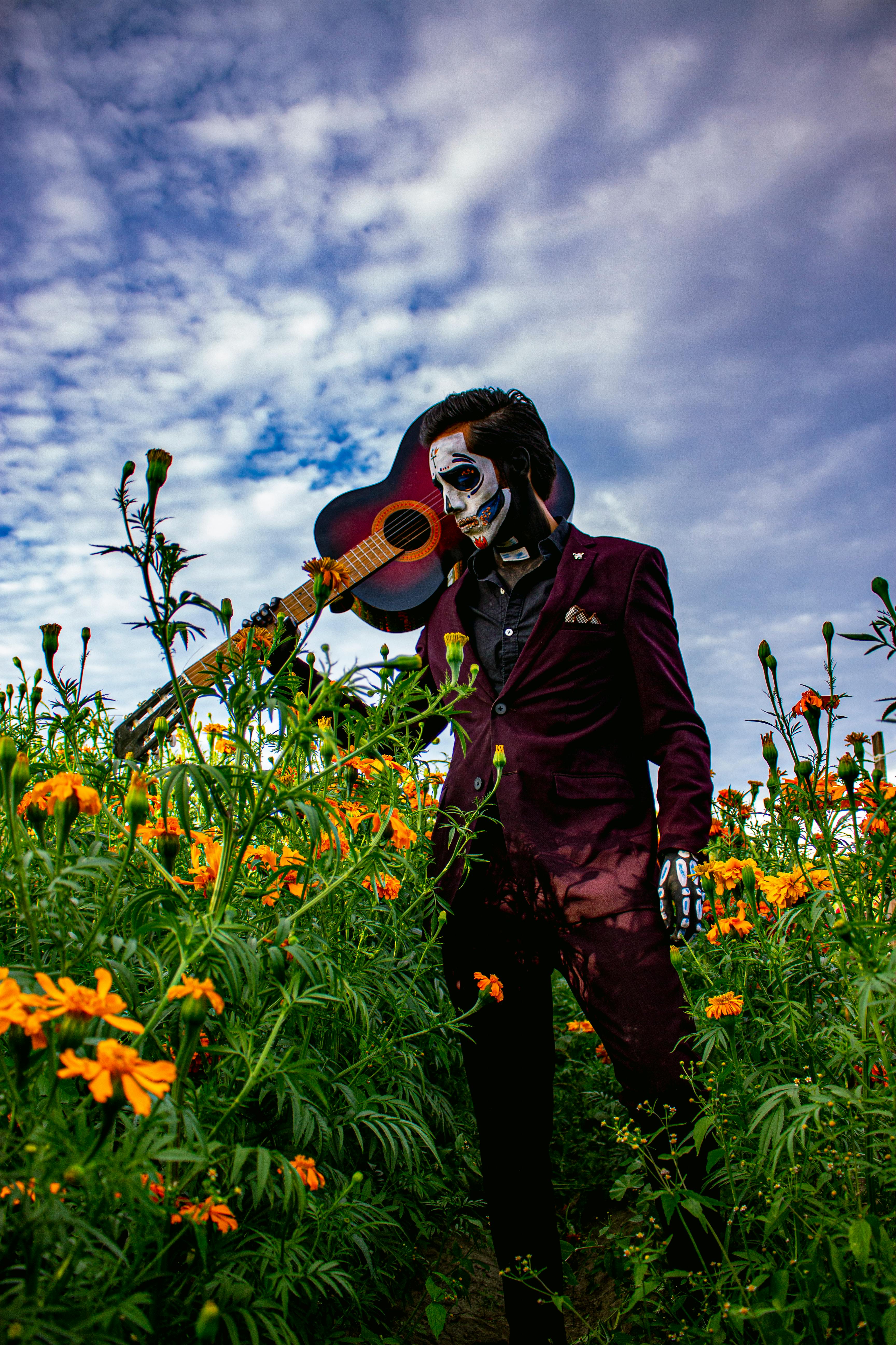 A Man in Maroon Suit Jacket Holding a Guitar · Free Stock Photo