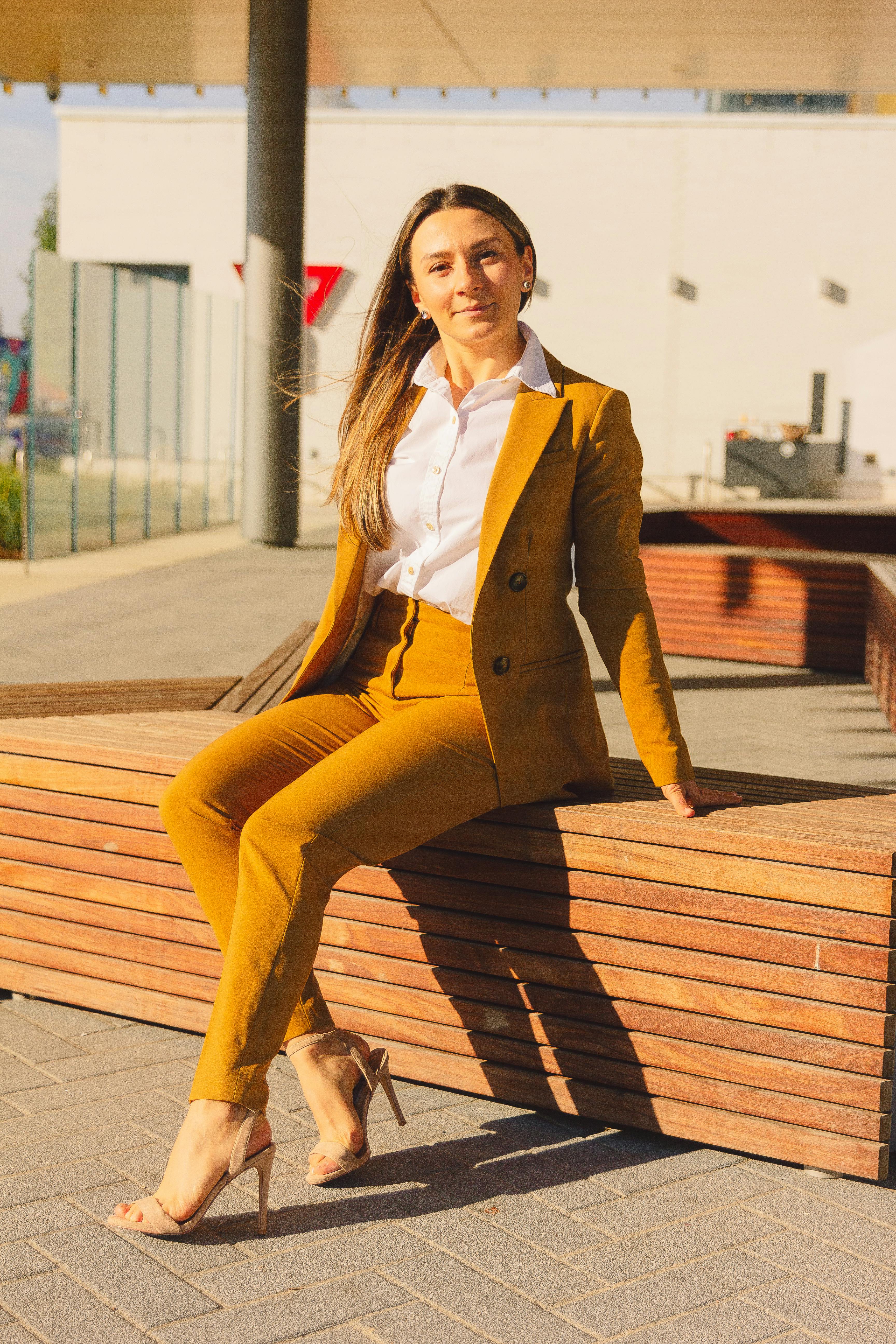 A Woman in Brown Suit Sitting on Brown Wooden Bench · Free Stock Photo