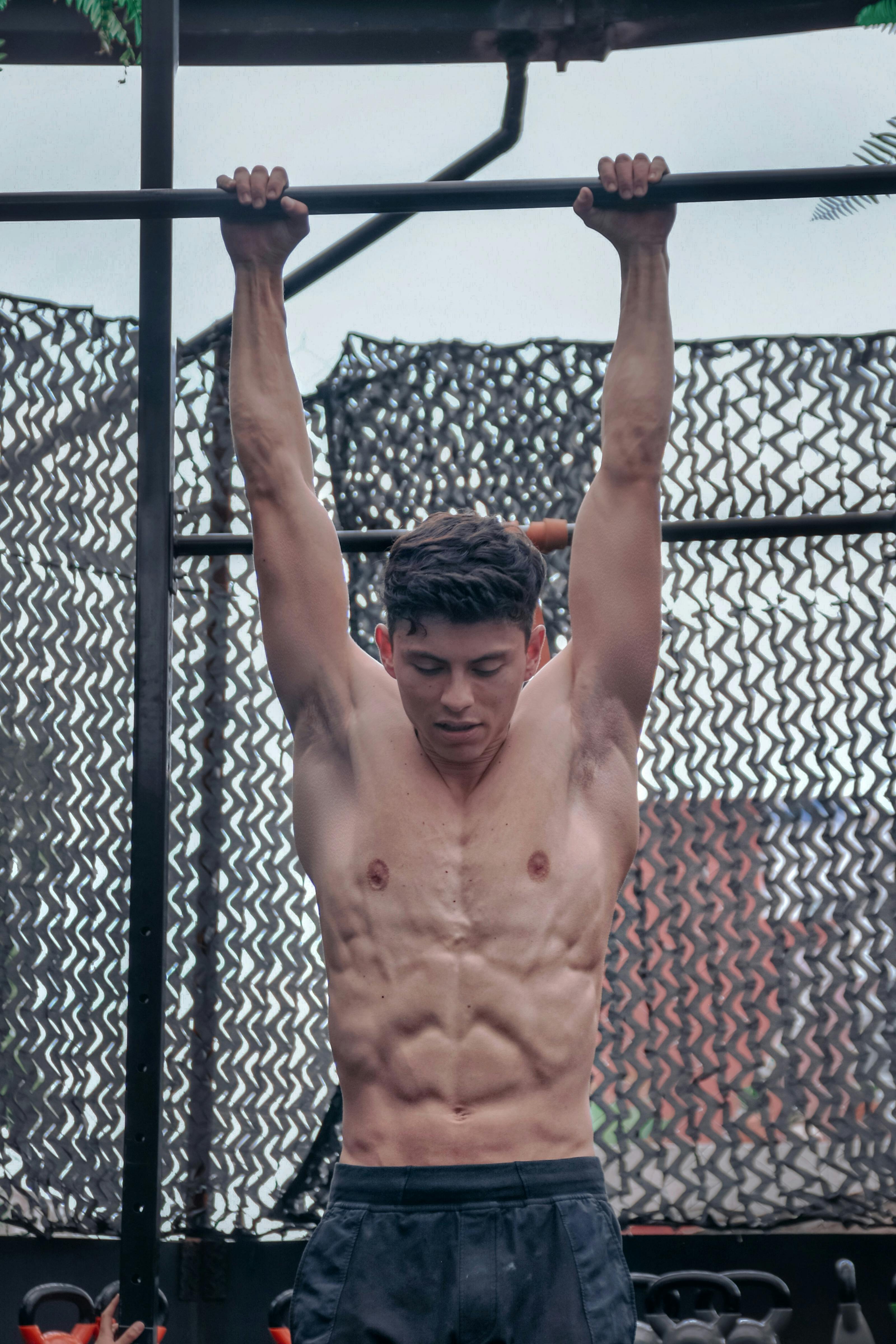 A Muscular Man Hanging on a Bar · Free Stock Photo