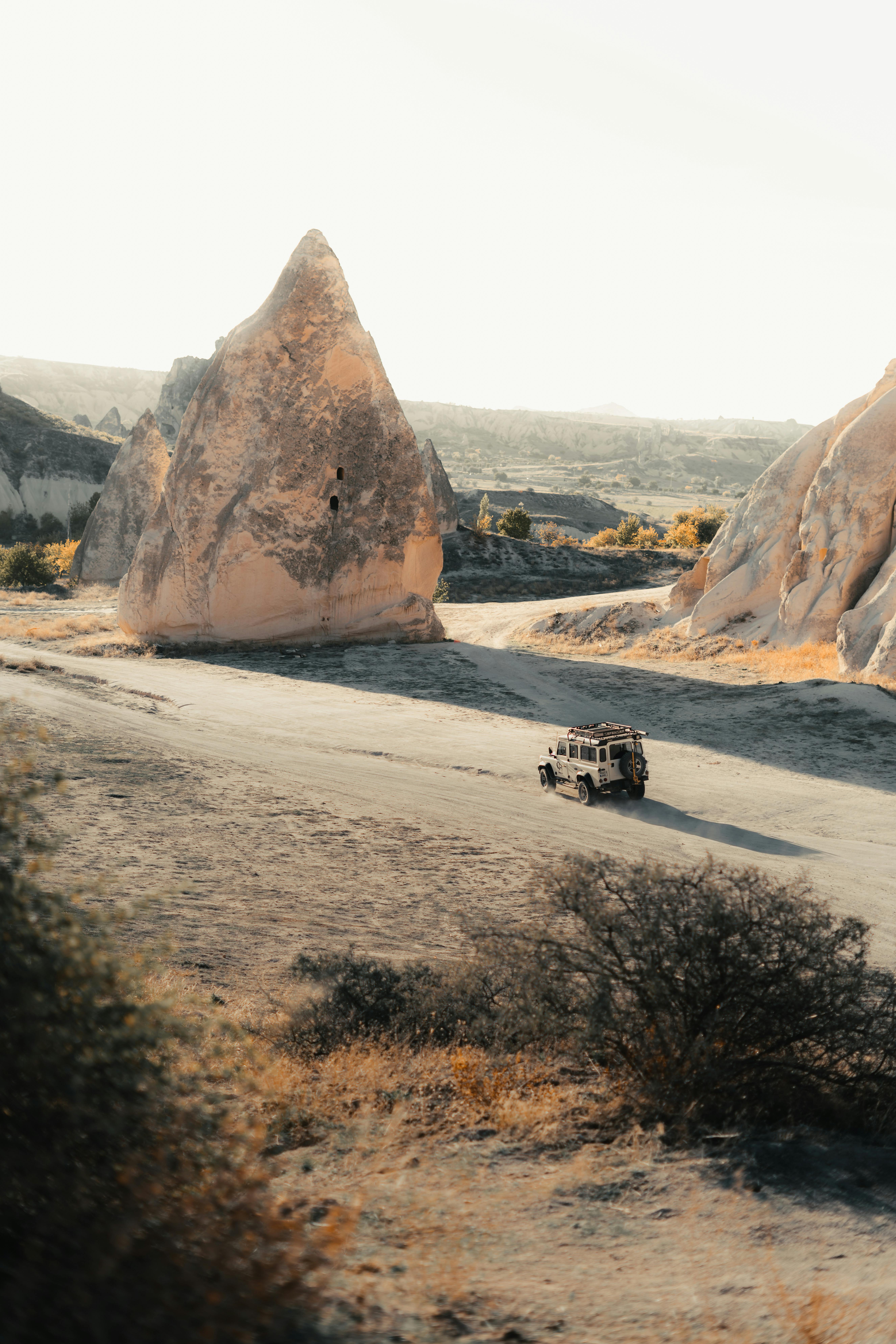Car on Dirt Road among Rock Formations · Free Stock Photo