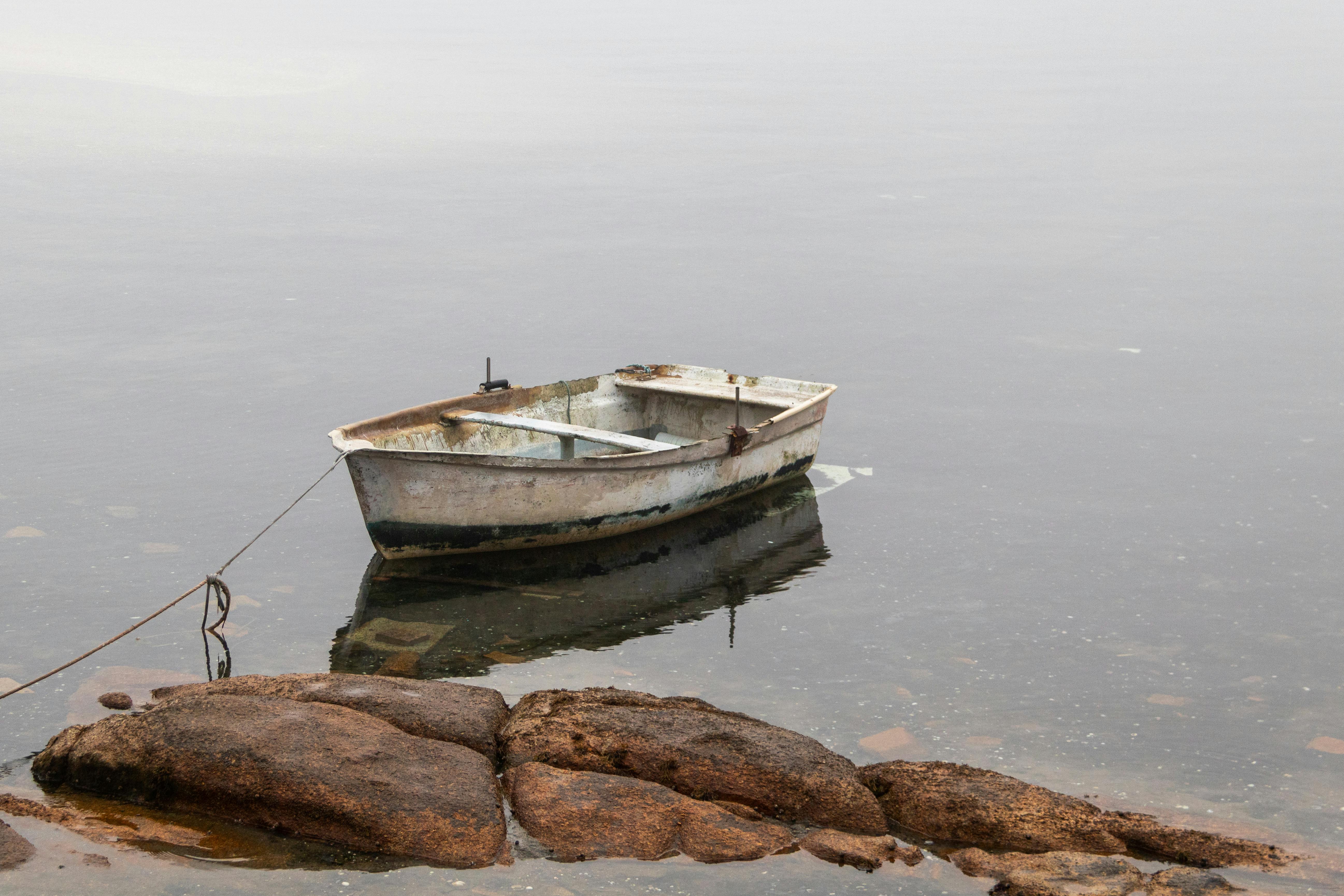 A Boat on Water Near the Rock · Free Stock Photo