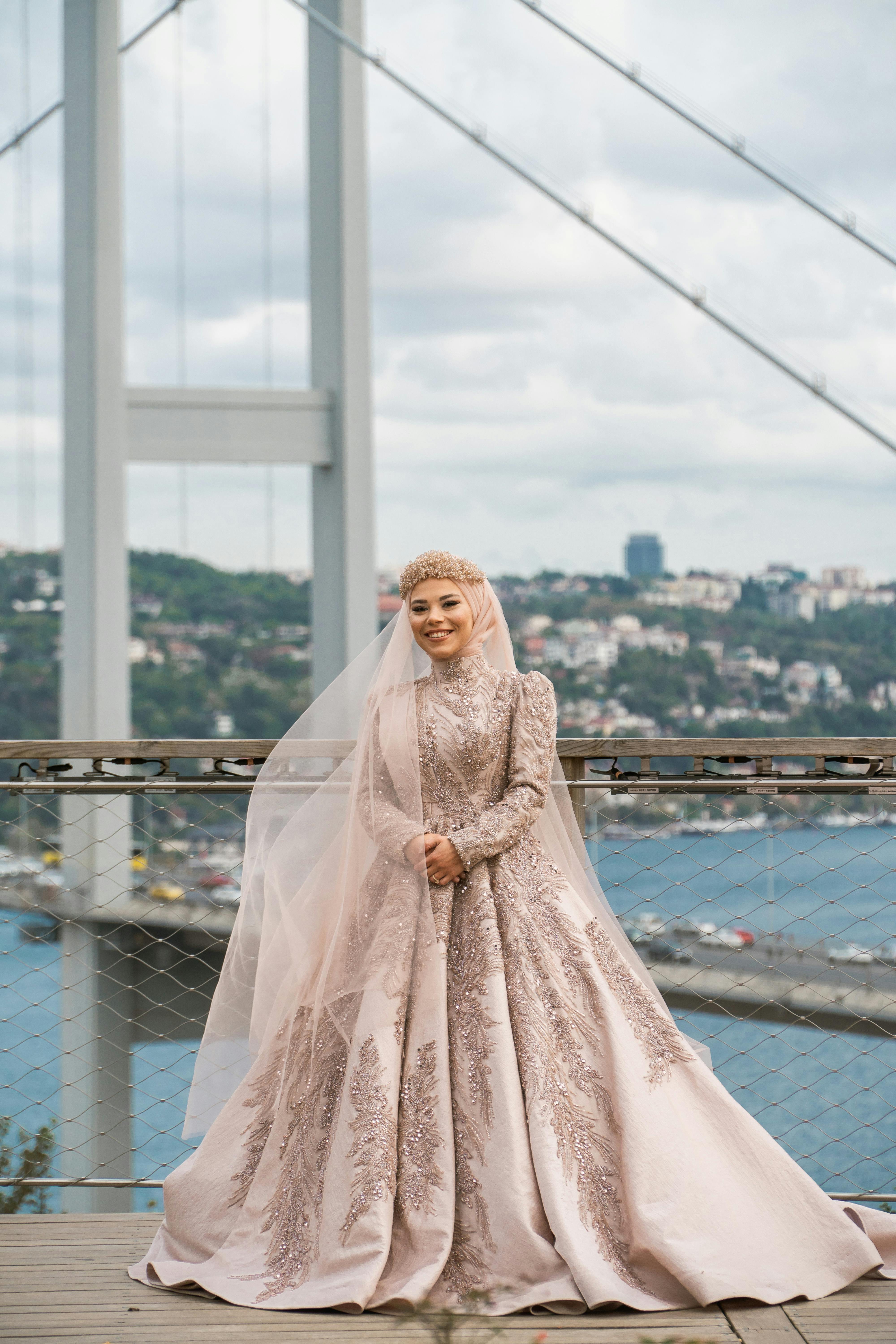 Bride in Traditional Gown Posing on Bridge · Free Stock Photo