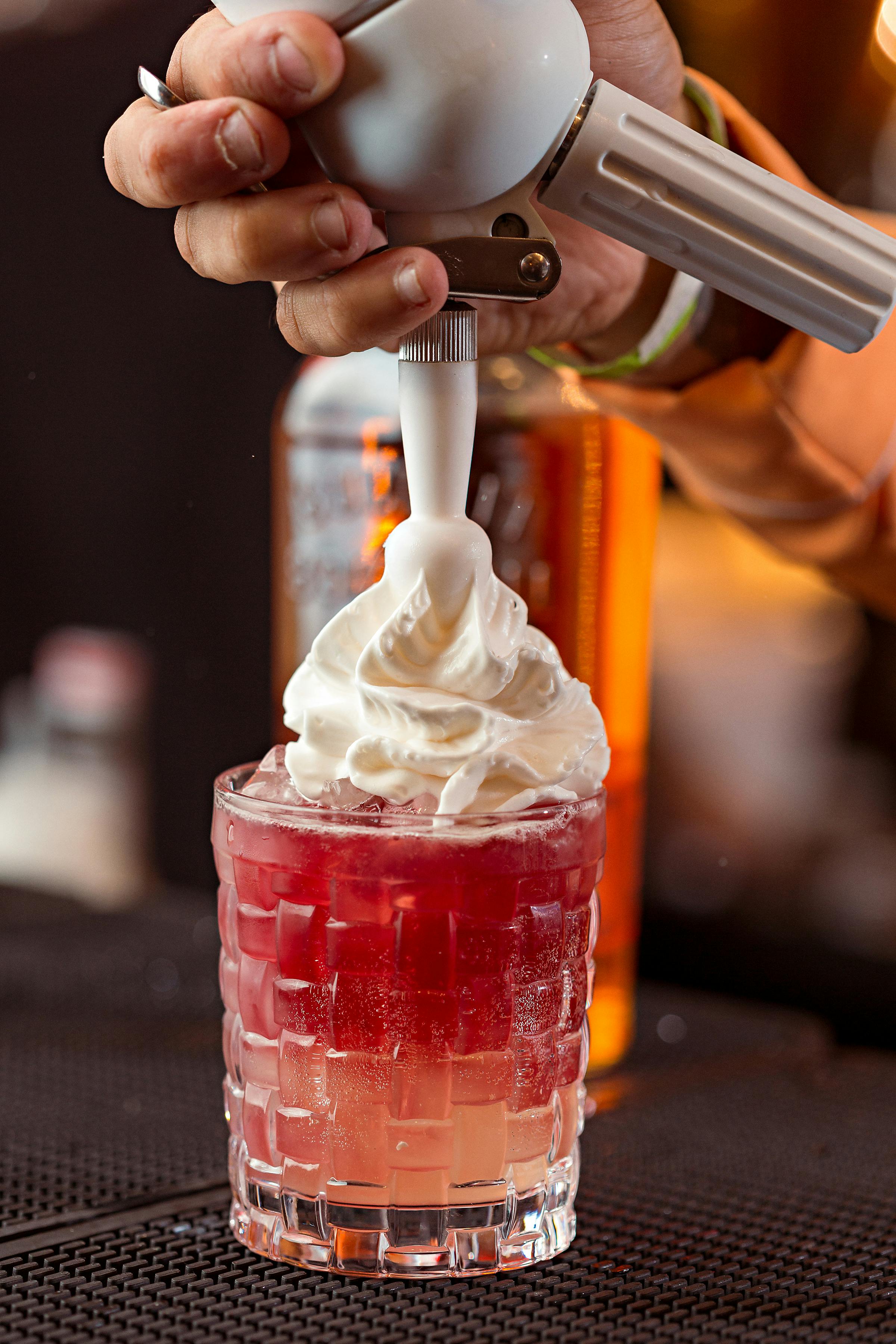 Hand Adding Whipped Cream on Top of Cocktail · Free Stock Photo