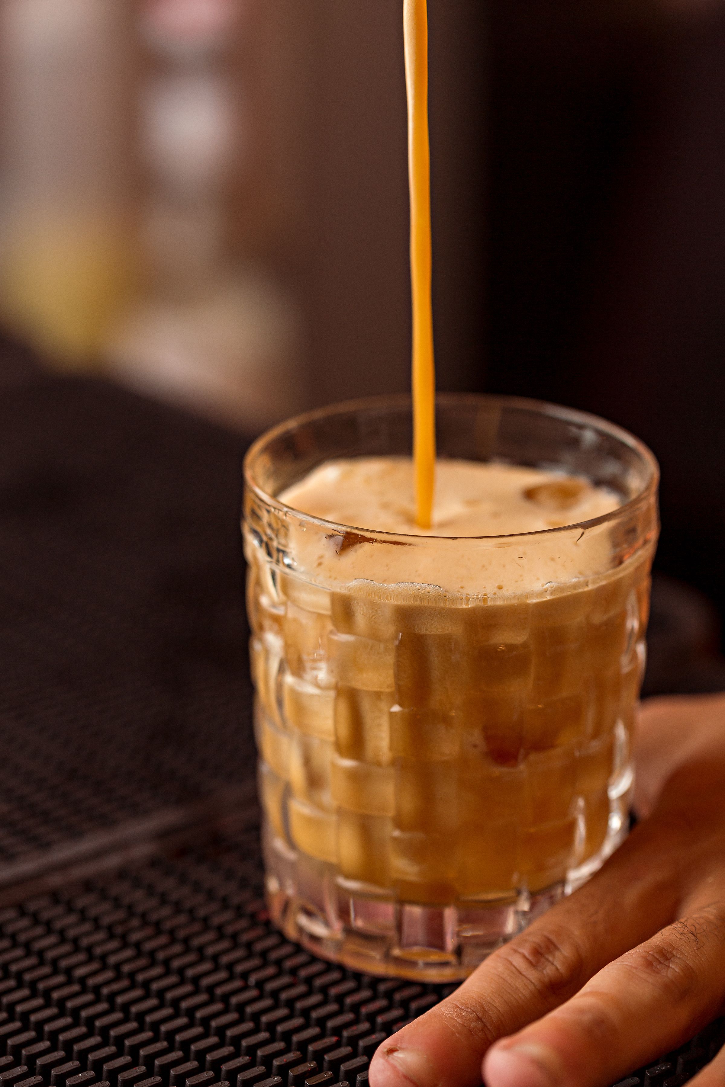 Close-up of hand pouring drink from cocktail shaker into glass · Free ...