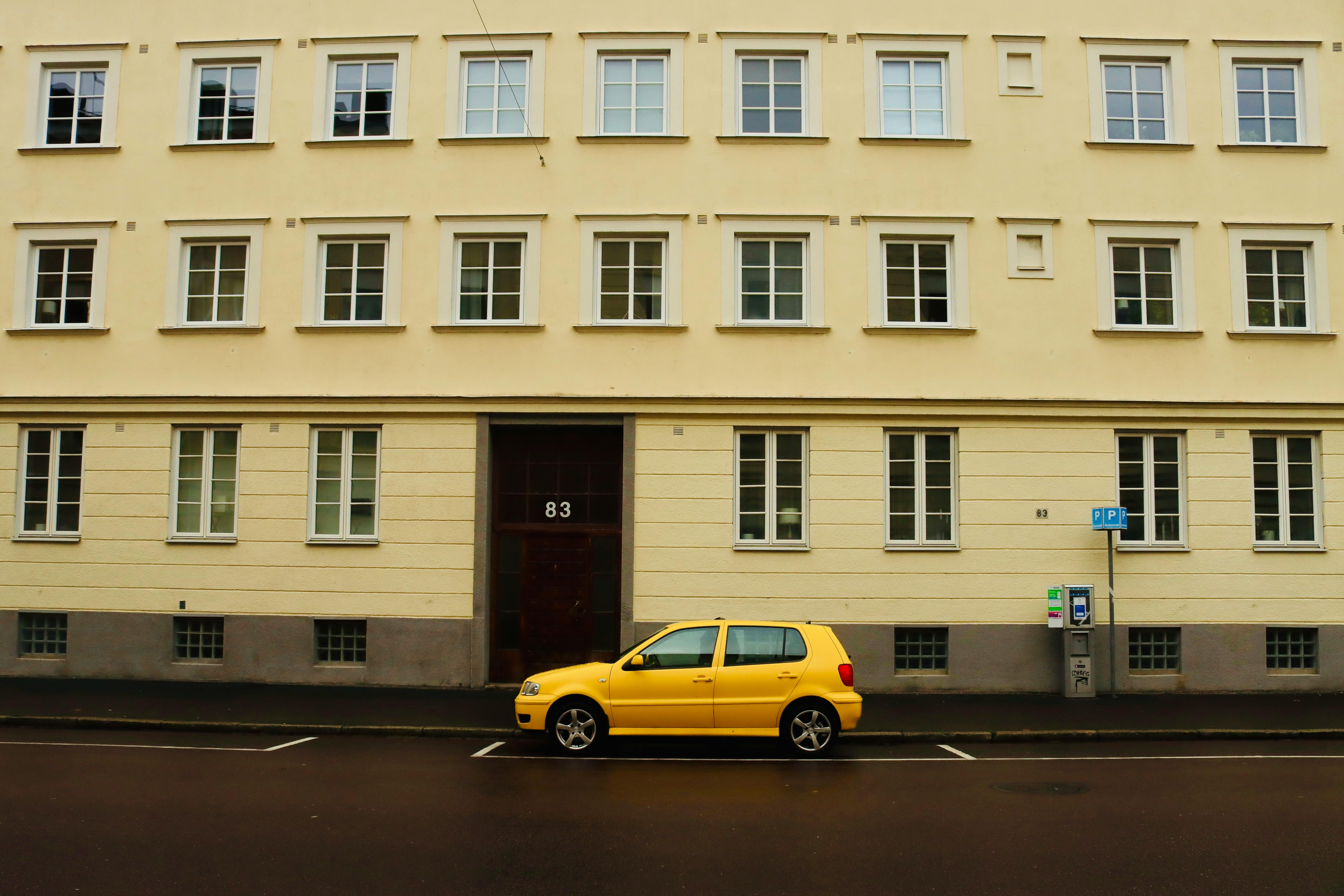 Yellow Vehicle Parked in Front of a Building · Free Stock Photo