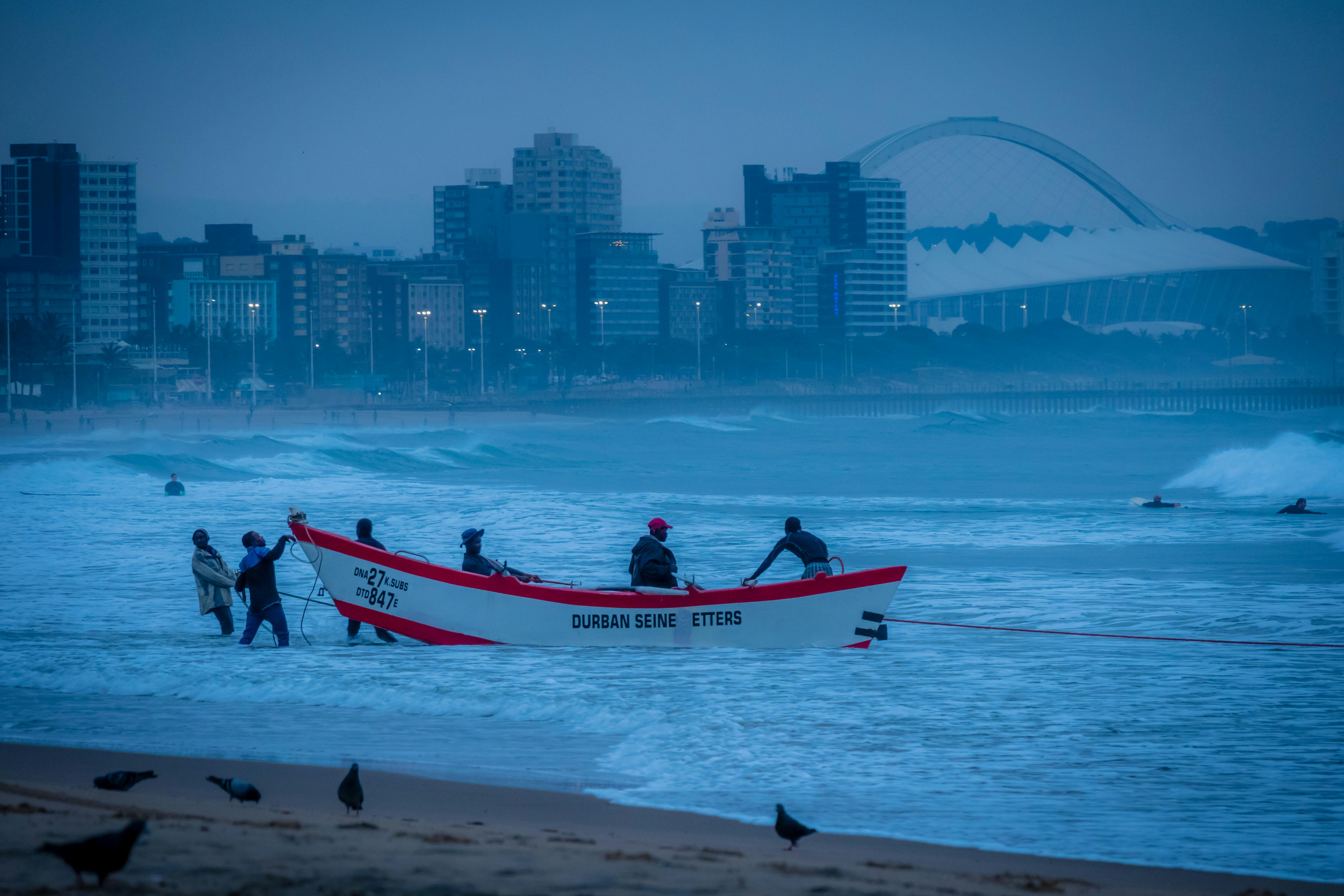 Men Pulling a Boat to the Shore during a Storm · Free Stock Photo