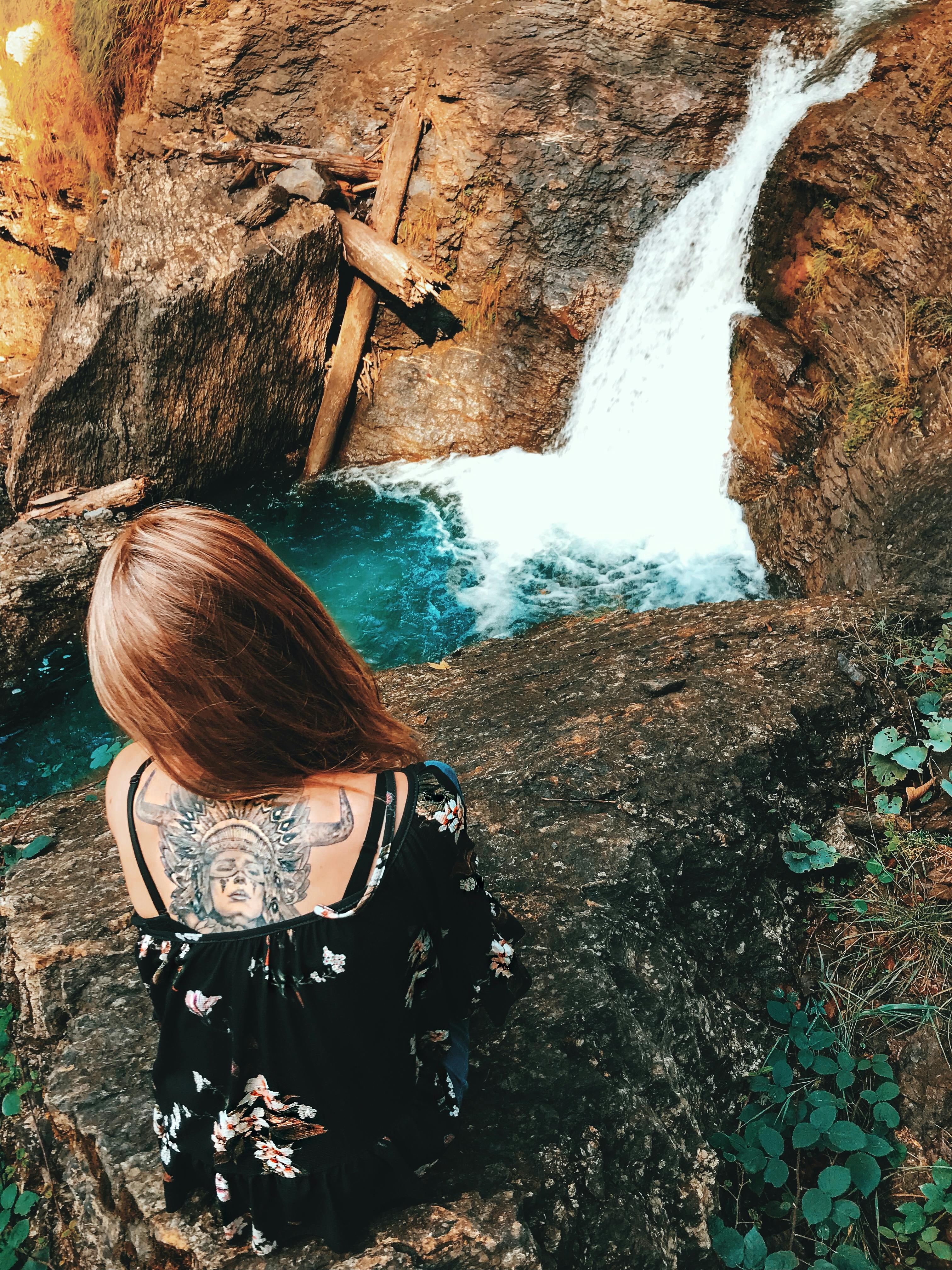Woman Sitting on Rock on Top of Waterfalls · Free Stock Photo