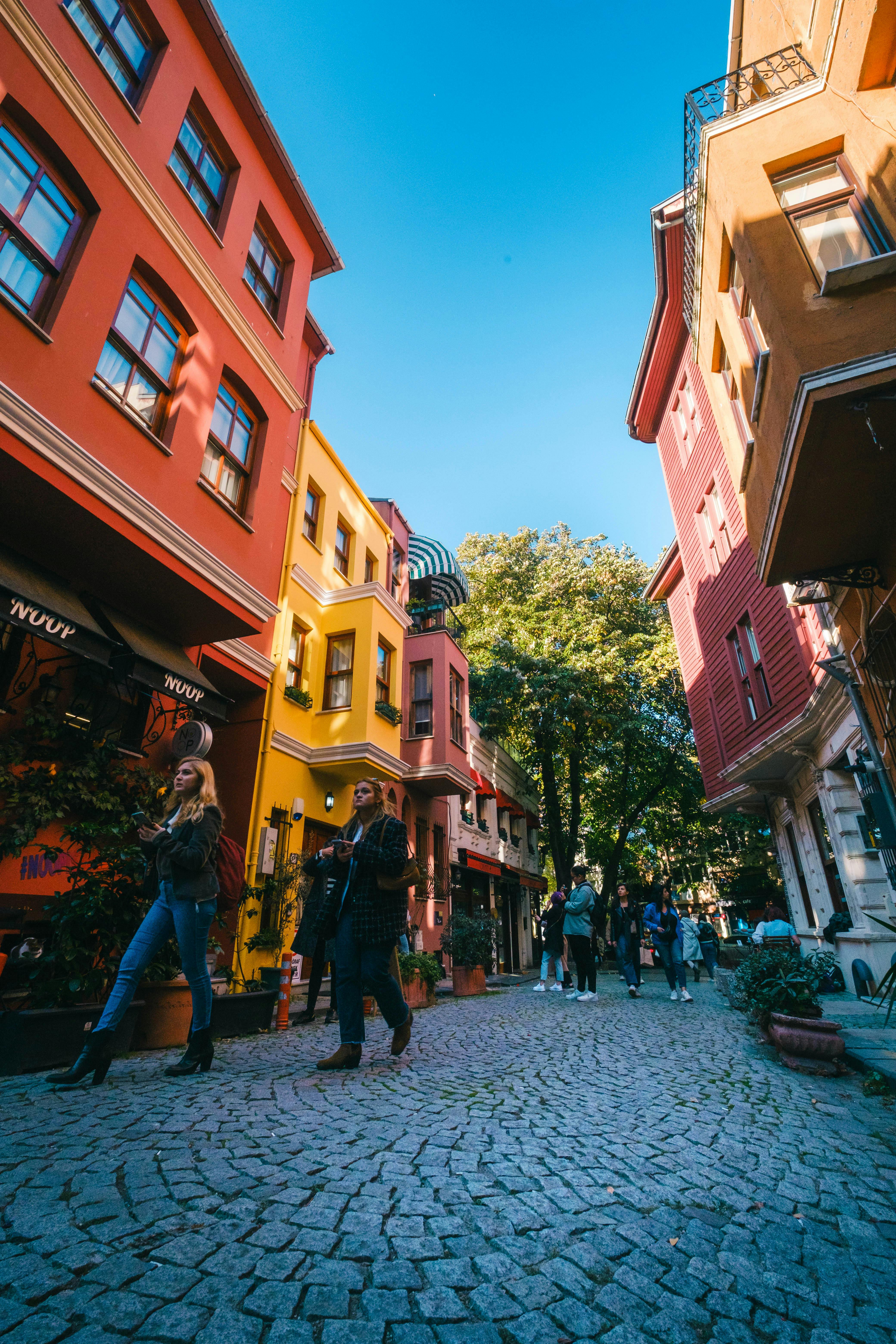 People Walking in the Middle of a Street with Colorful Buildings · Free ...