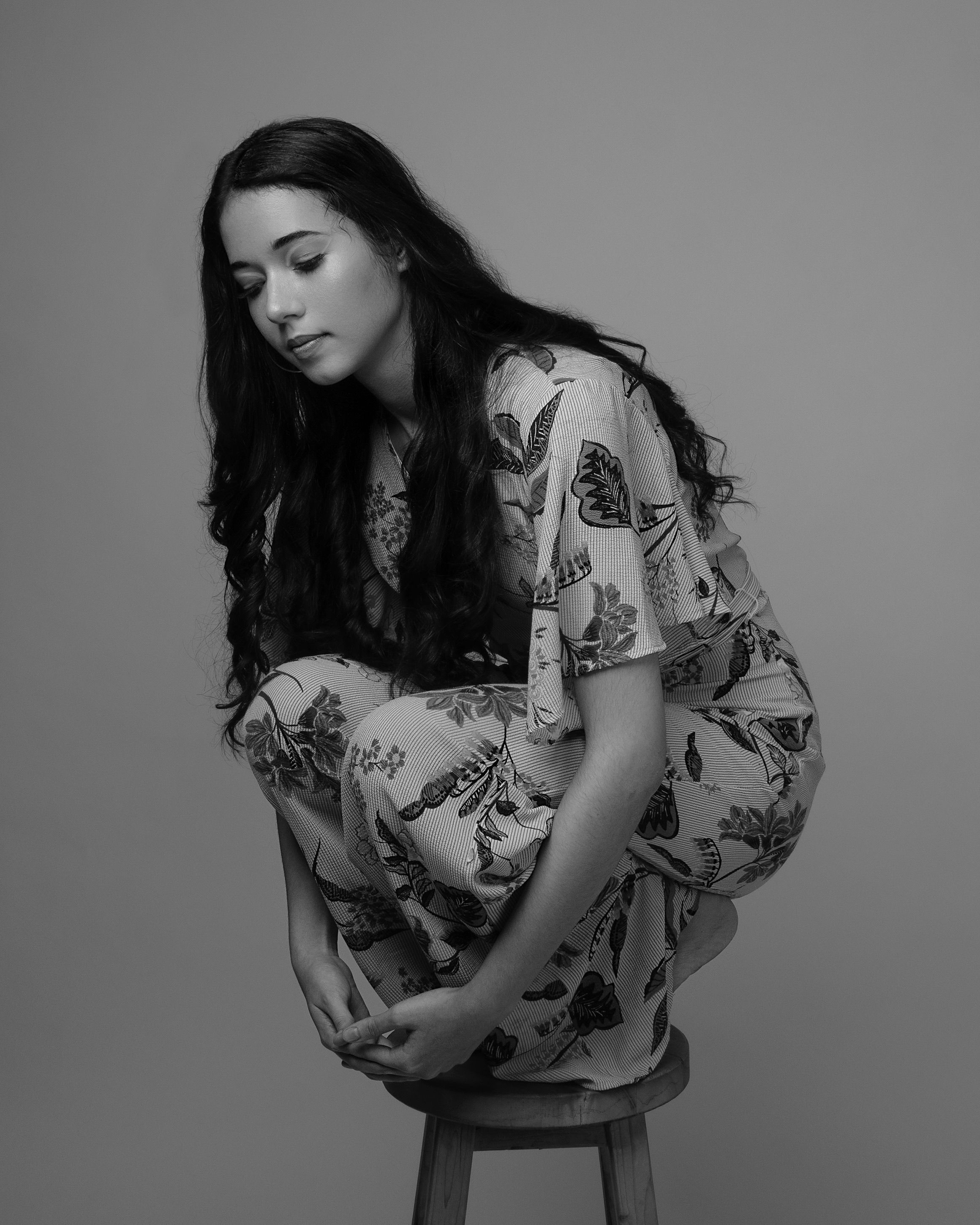 Monochrome Photo of a Woman Crouching on a Chair · Free Stock Photo