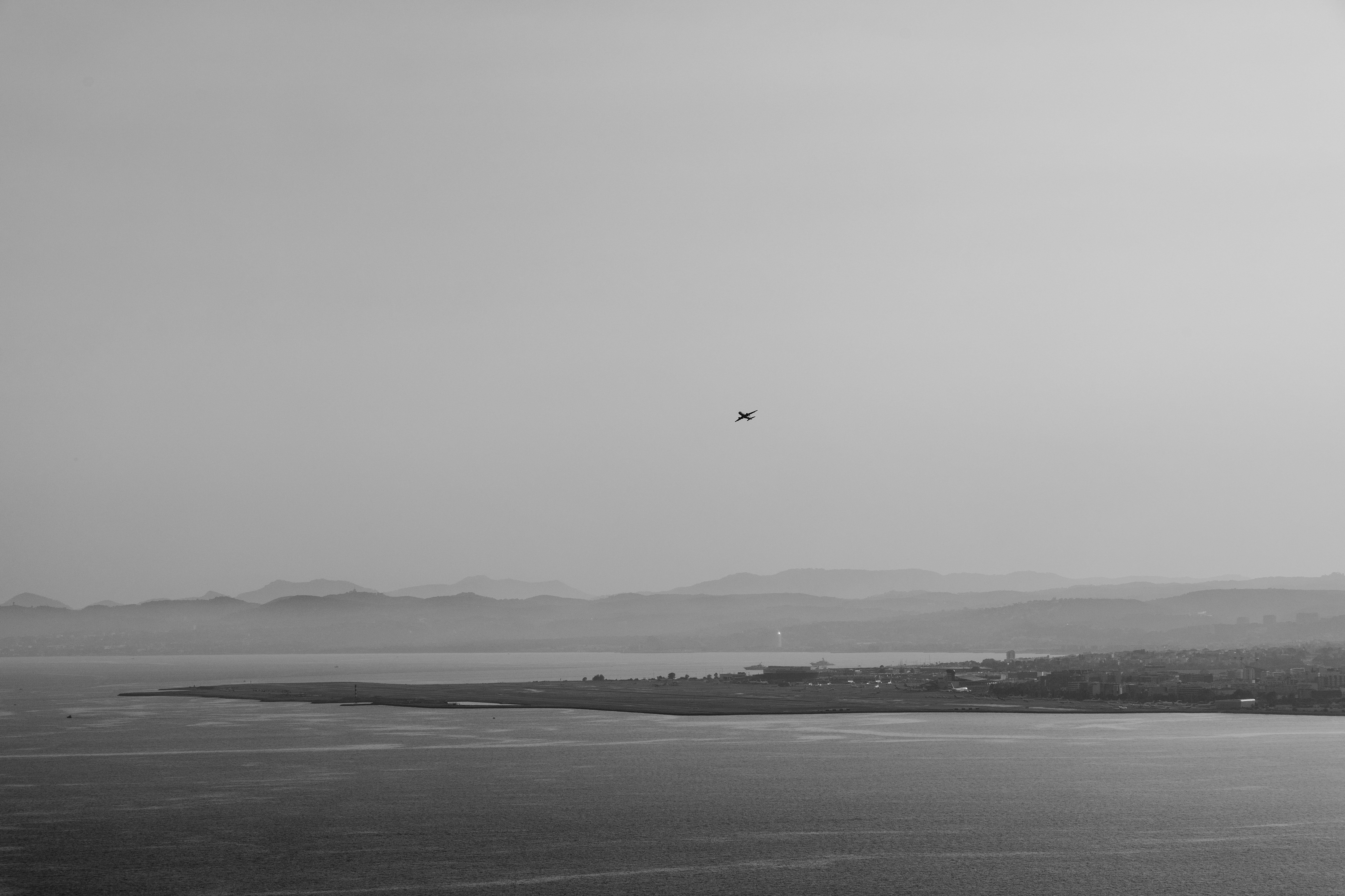 An Island Surrounded by the Sea in Grayscale Photo · Free Stock Photo