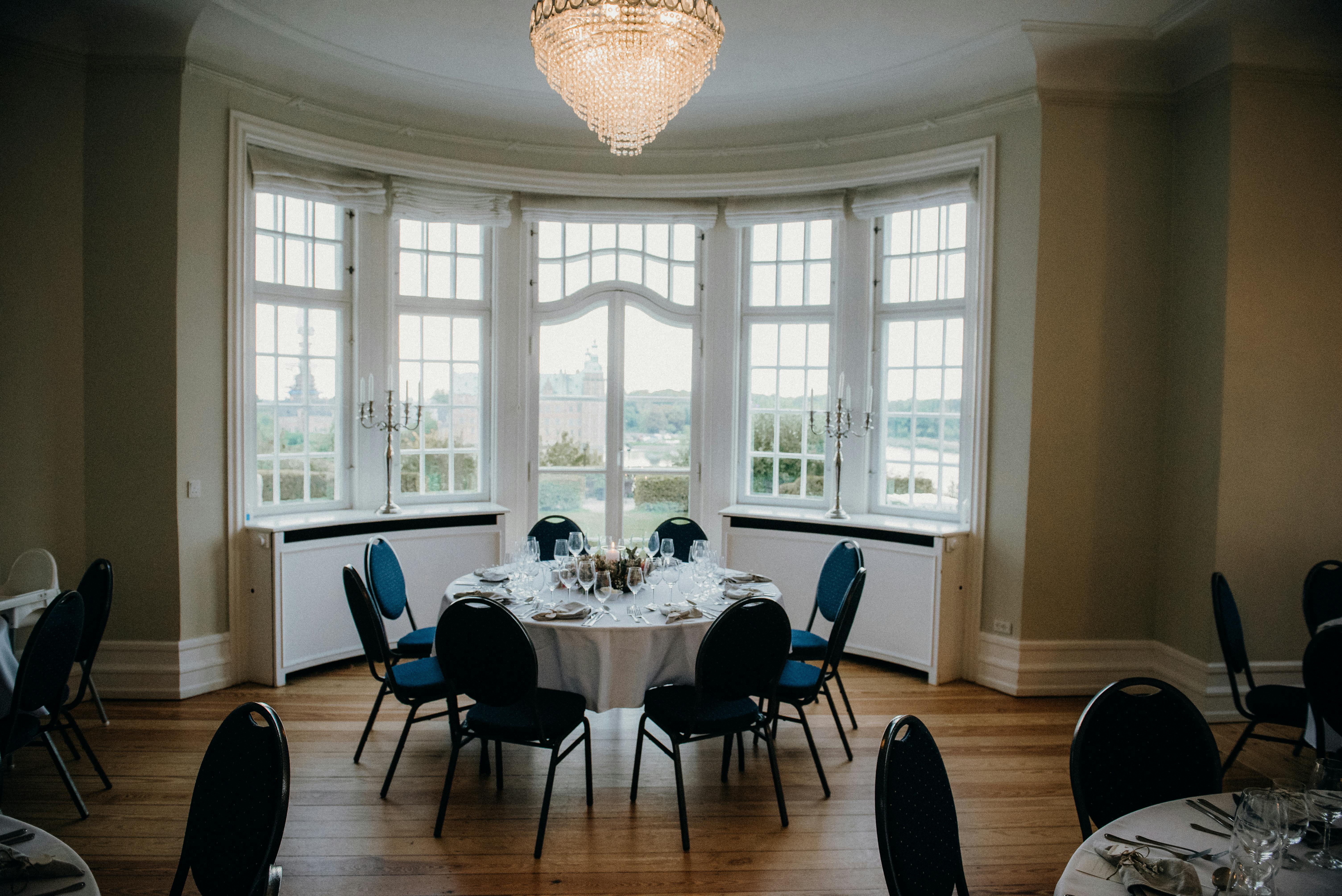 A Dining Table and Chairs Near the Glass Windows · Free Stock Photo