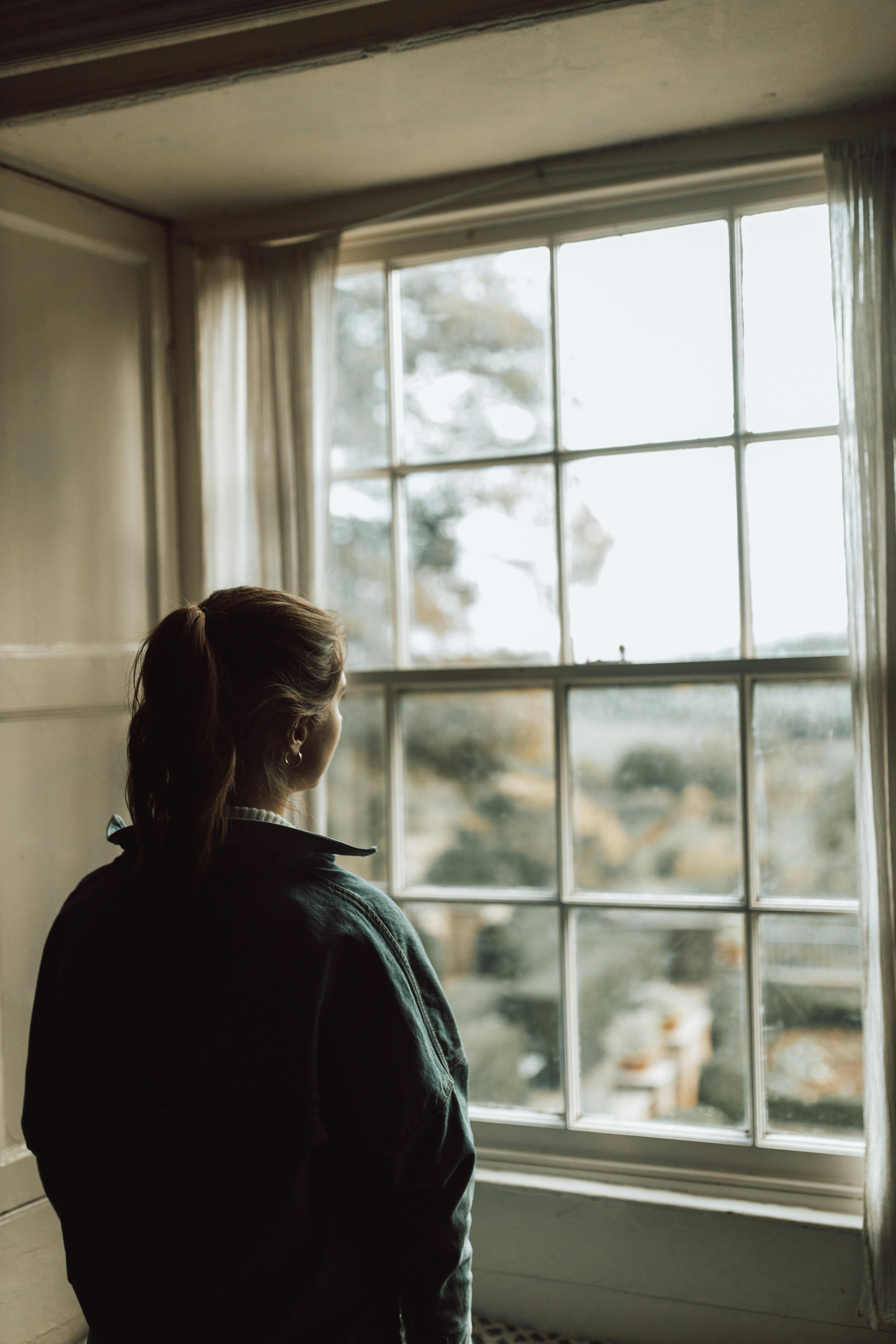 A Woman Standing by the Window · Free Stock Photo