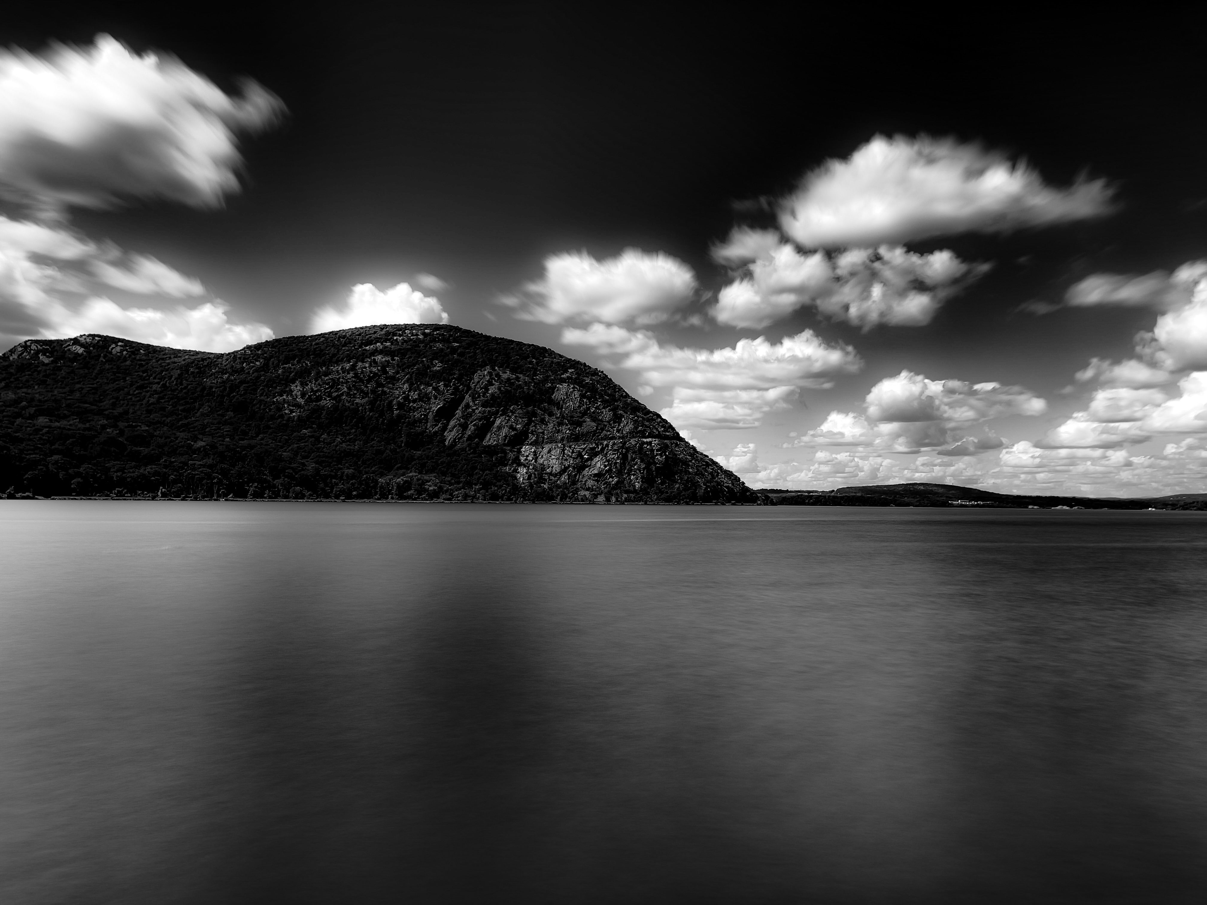 Grayscale Photo of a Coastal Mountain · Free Stock Photo